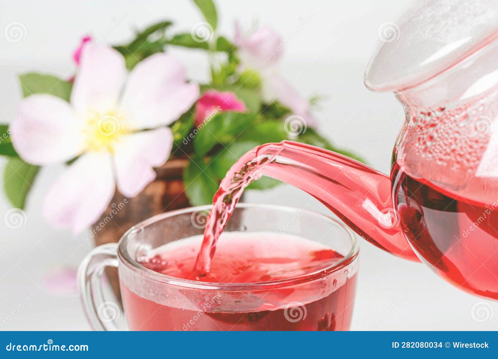 White Ceramic Pitcher Pouring Liquid into a Clear Glass Mug Stock Photo ...