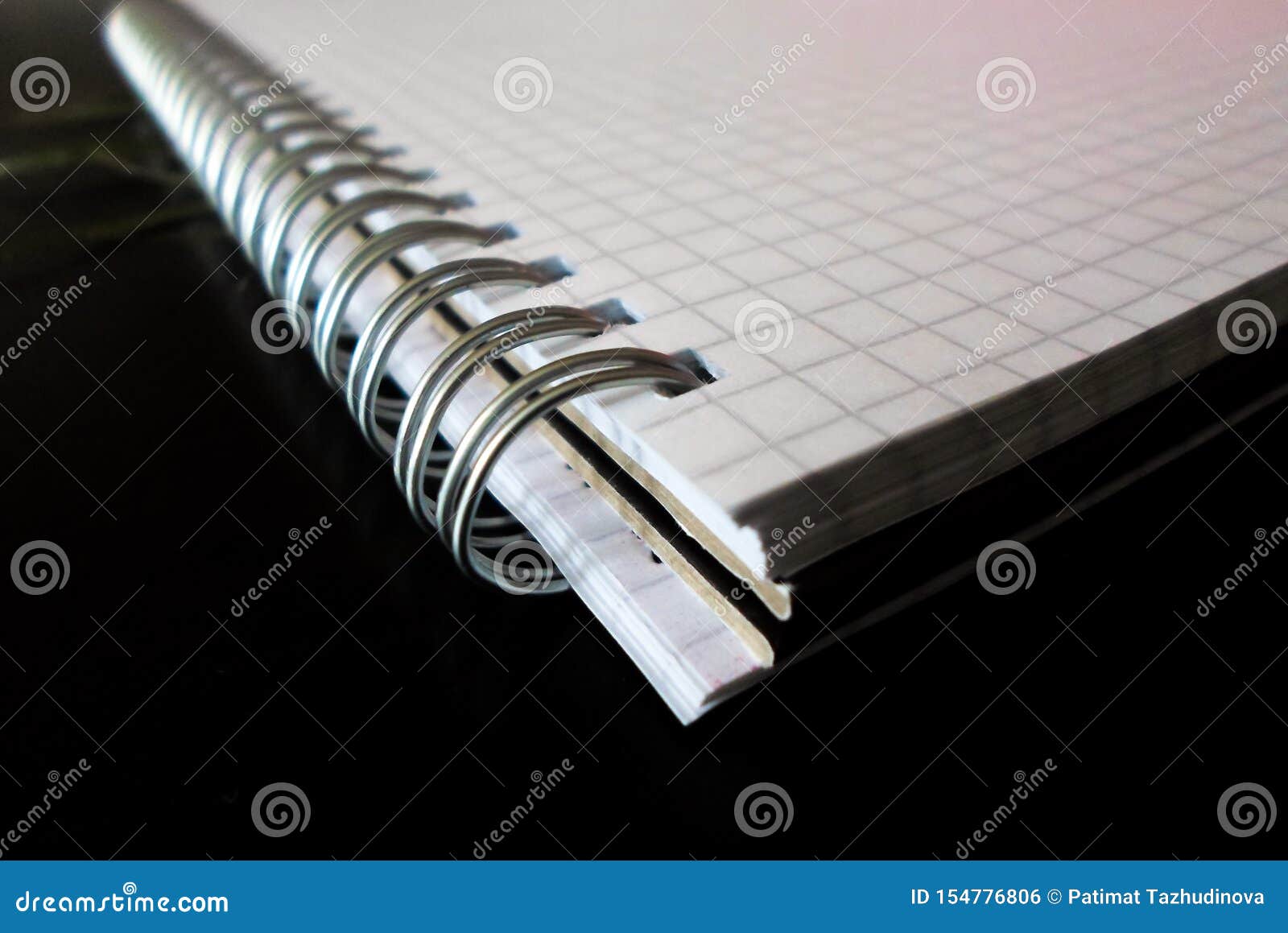 White Checkered Notepad on a Black Table. Iron Spiral Notebook Stock ...