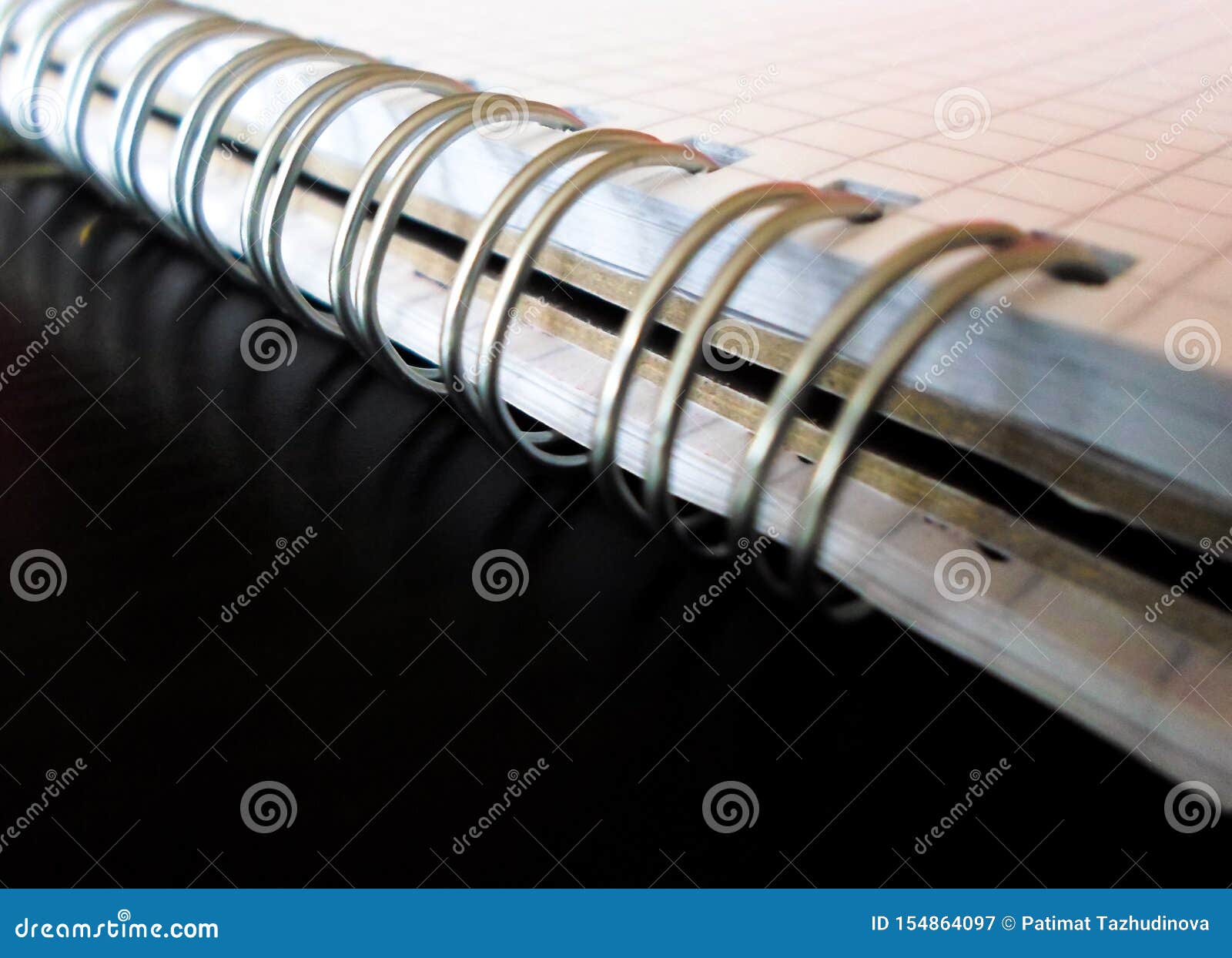 White Checkered Notepad on a Black Table. Iron Spiral Notebook Stock ...