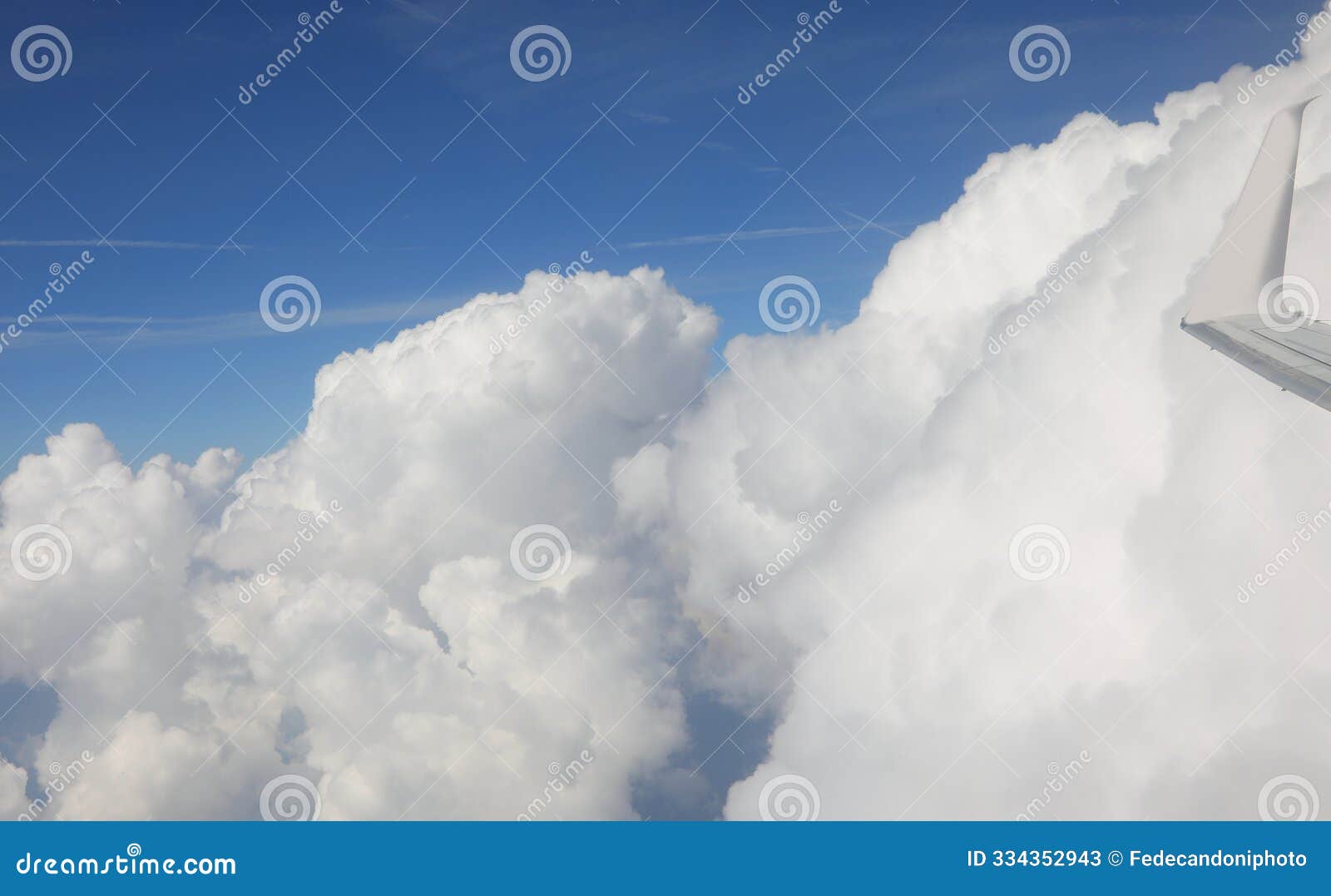 White Clouds from Above and a Piece of Airplane Wing during ...