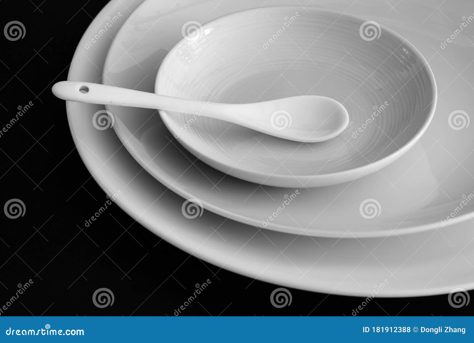 White Color Set of Plates with Spoon on Black Table Stock Photo - Image ...