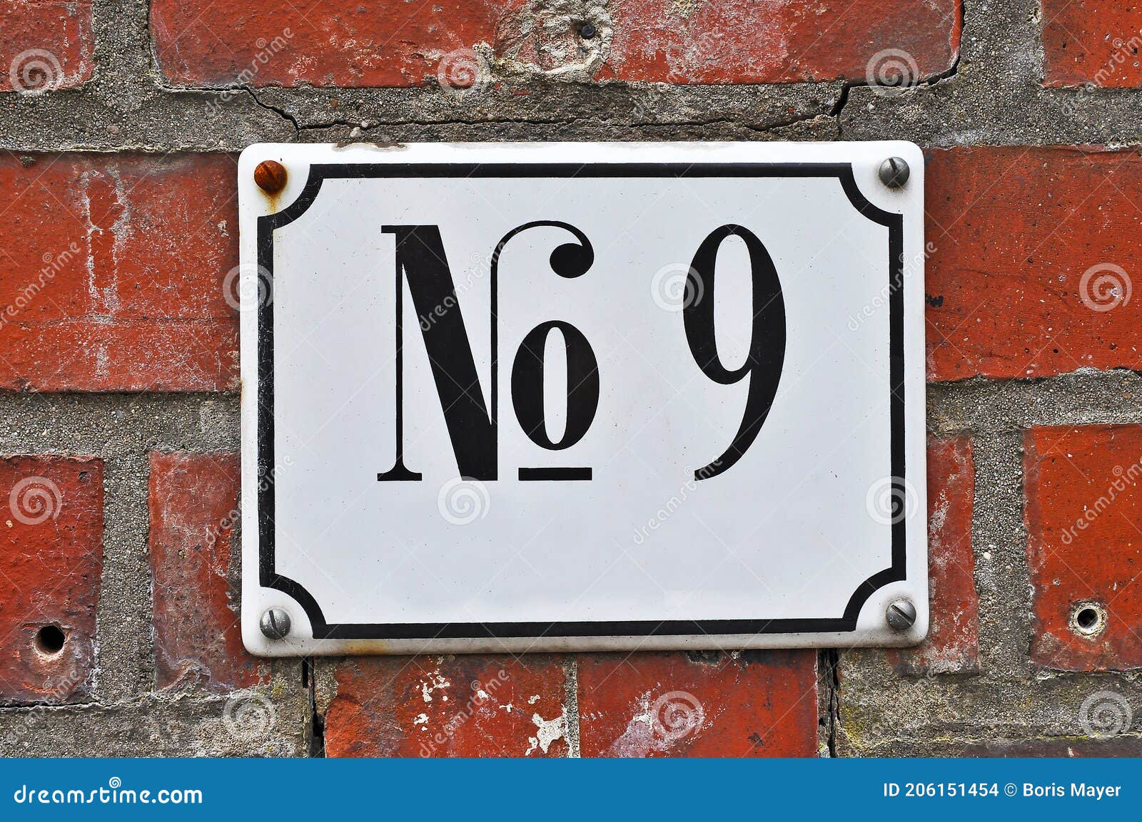 A White Colored House Number Plaque, Fixed on a Brick Wall, with the ...
