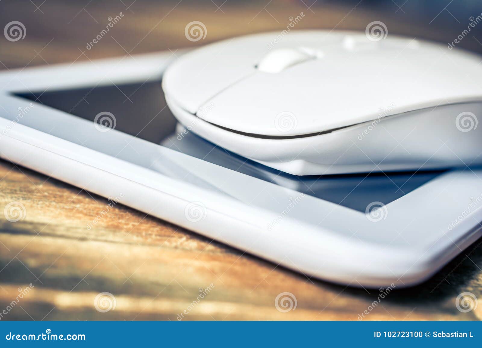 White Computer Mouse on Top of a White Tablet on Wooden Table Stock ...