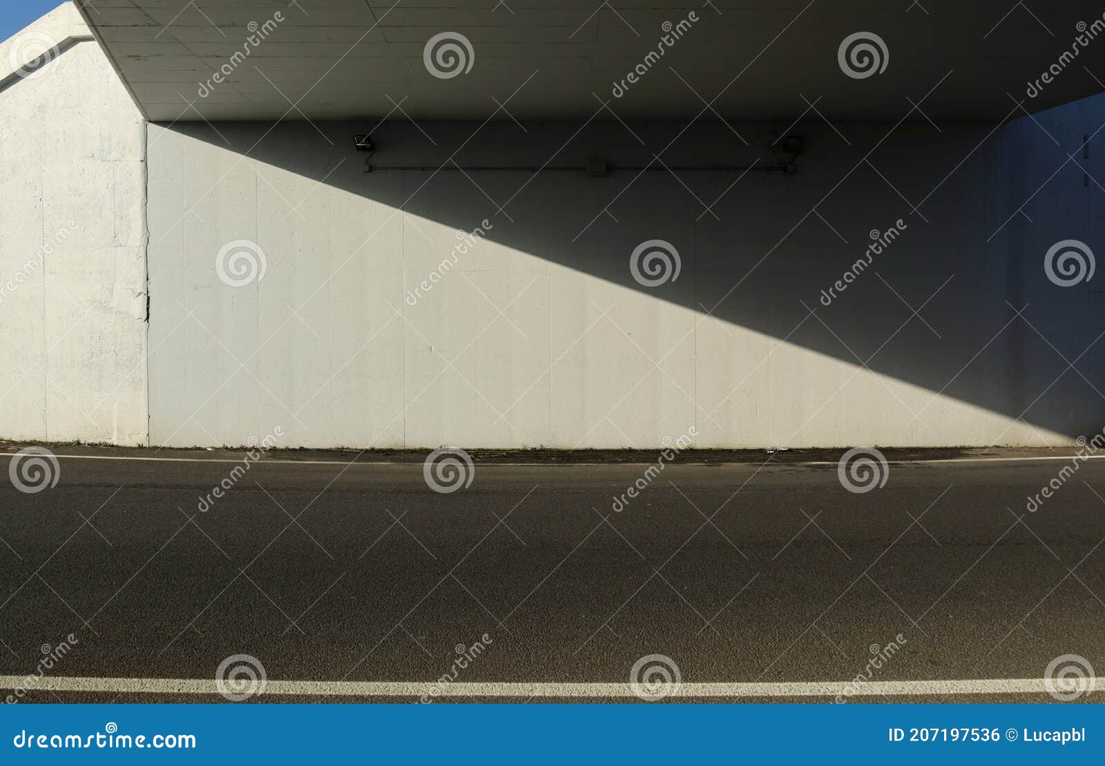 White Concrete Wall Under an Underpass Divided in Two Obliquely by a ...