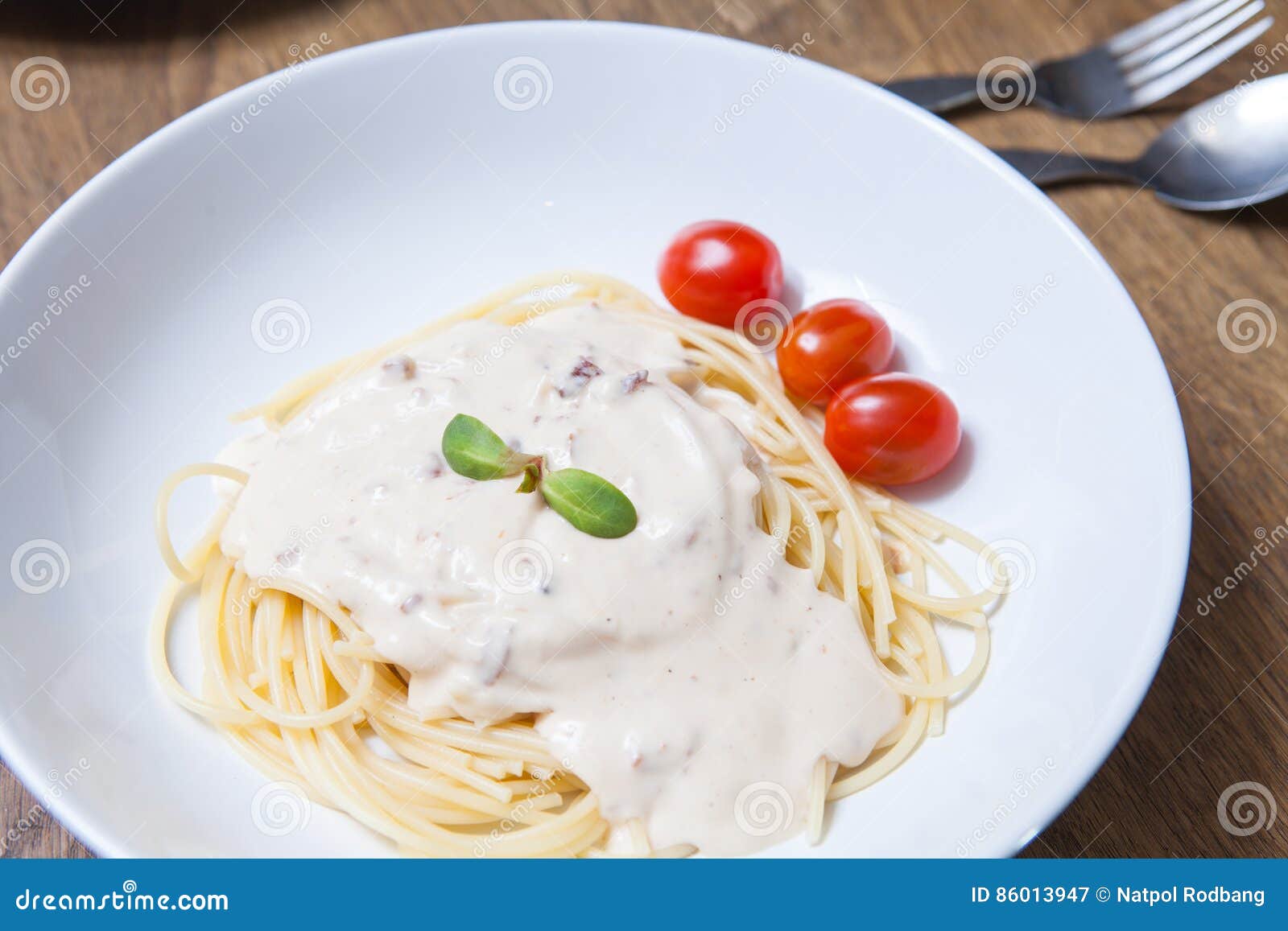 White Cream Sauce Spaghetti in White Plate on a Wooden Table Stock ...