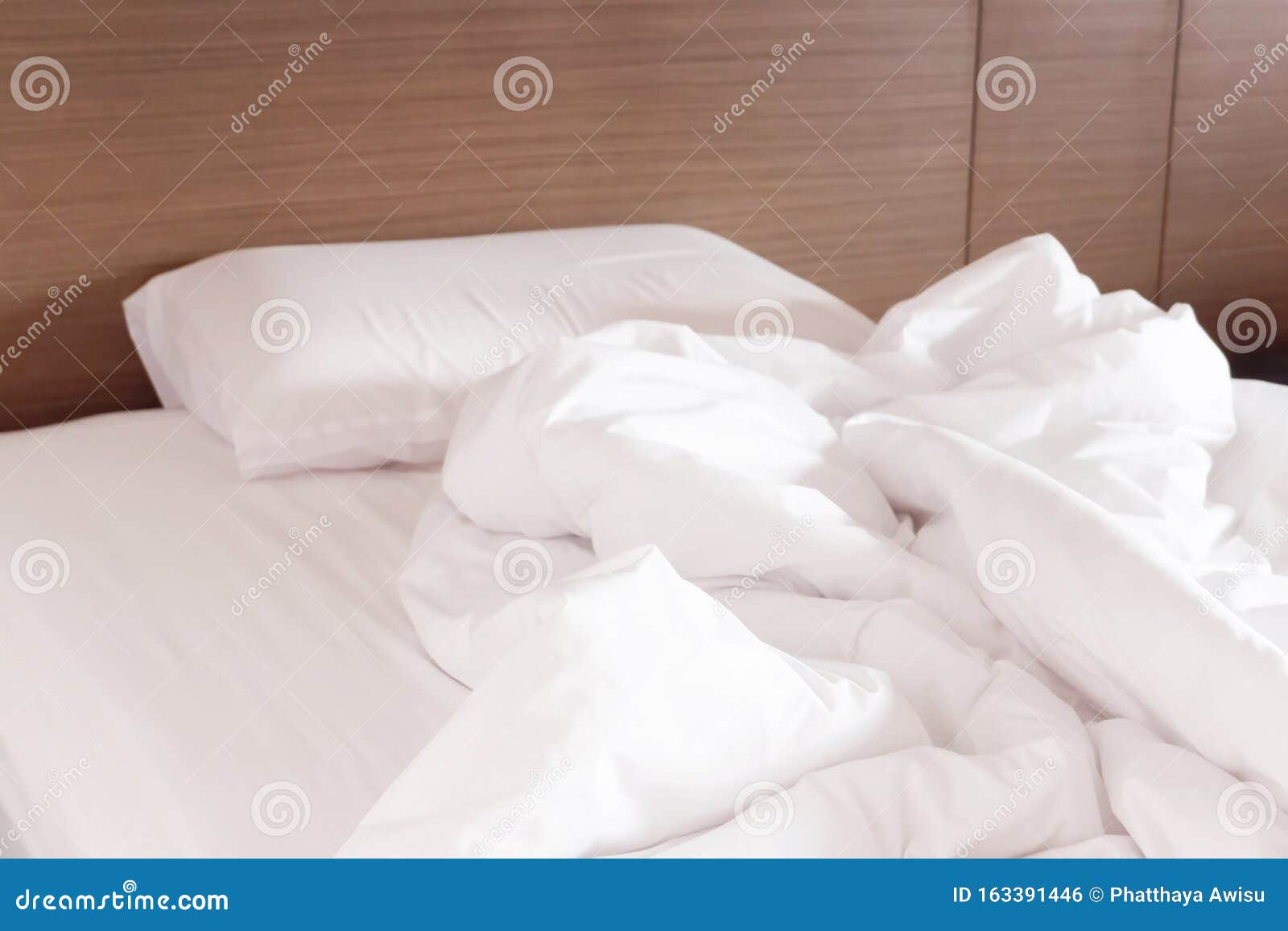 White Crumpled Bed Sheet and Messy Pillows in a Hotel Room Stock Photo ...