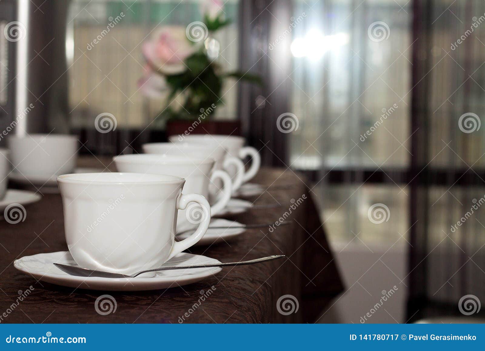 White Cups of Tea are in a Row on the Table with a Brown Tablecloth ...