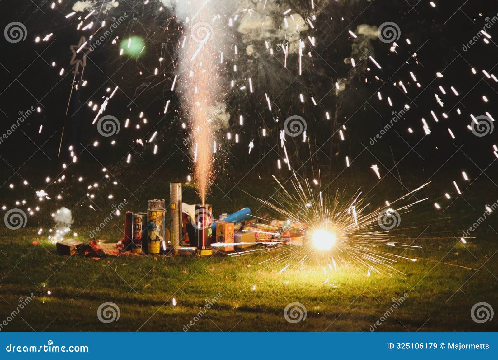 White Dash and Dot Backyard Fireworks with Red Spray on Green Grass ...