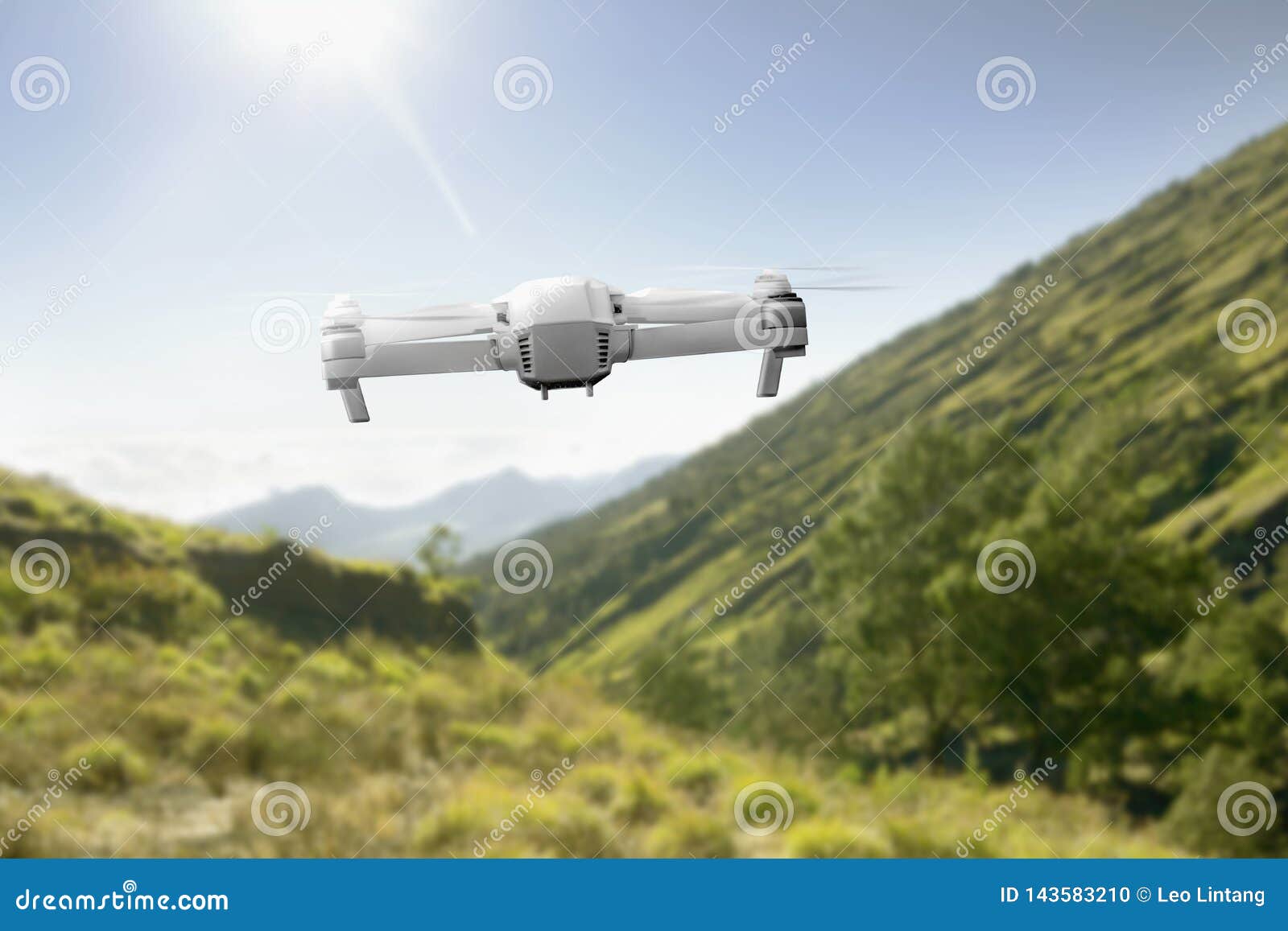 White Drone with Camera Flying Above the Mountain with Green Grass and ...
