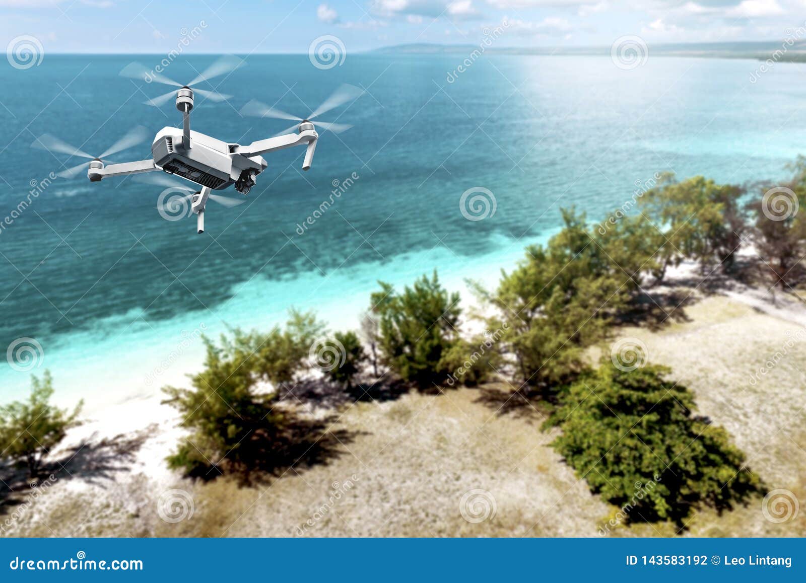 White Drone with Camera Flying Over the Beach with Green Trees and Blue ...
