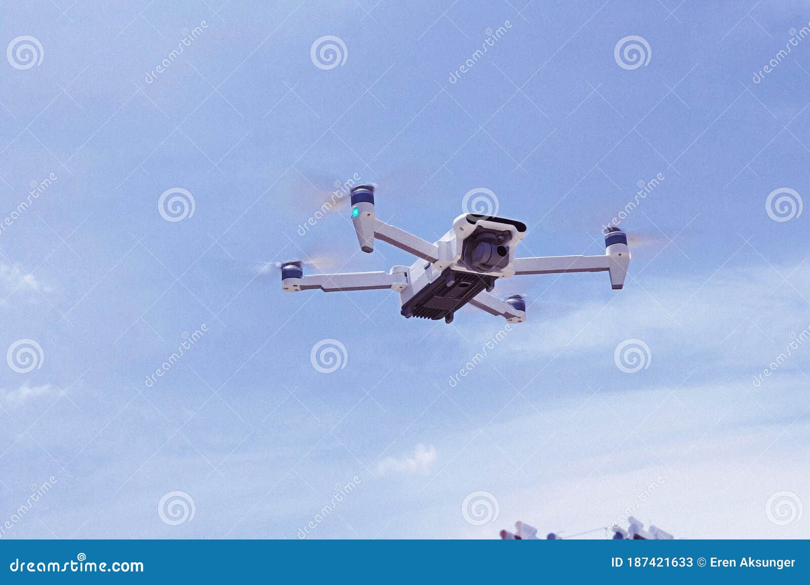 White Drone Hovering in a Bright Blue Sky. Drone Copter Flying with ...