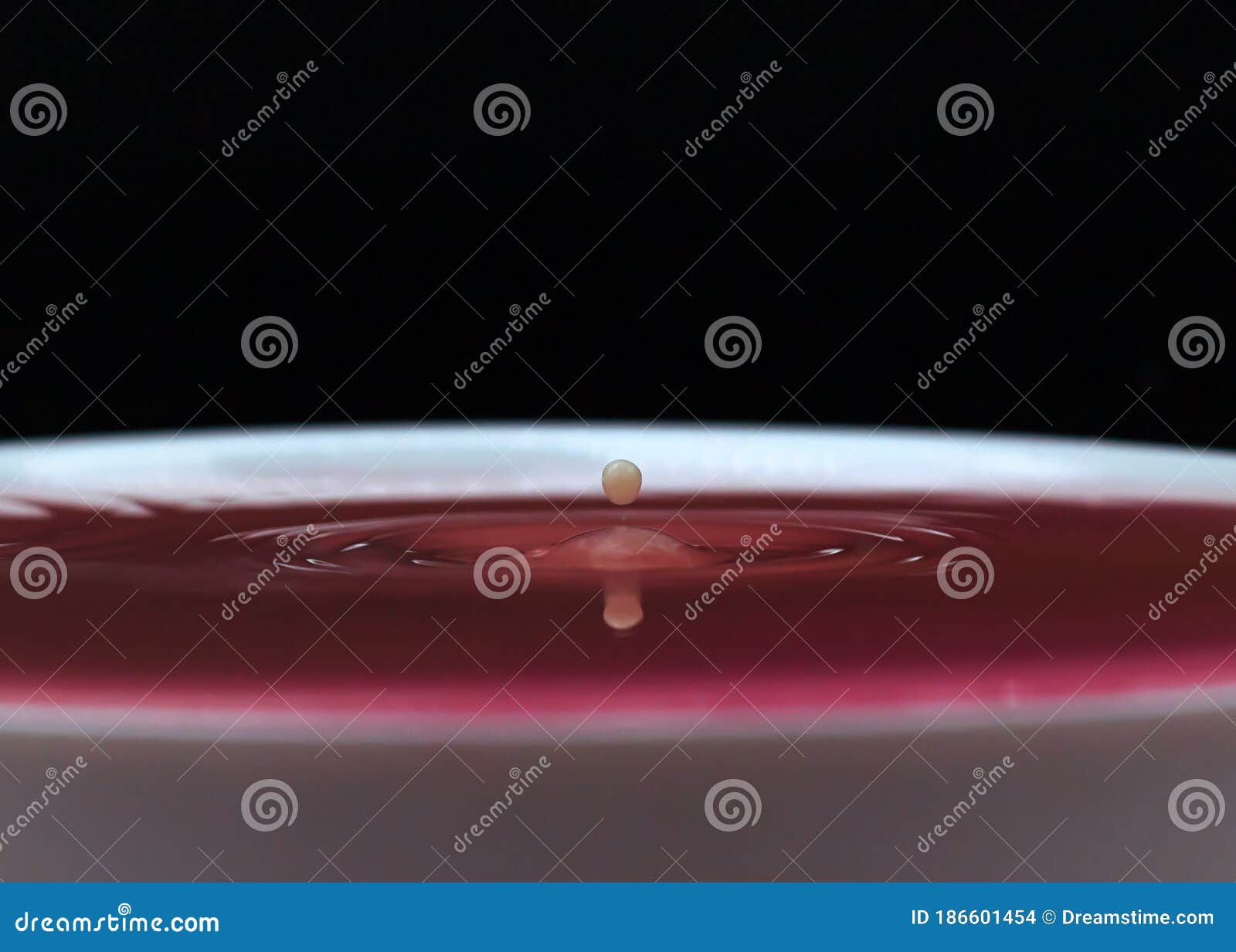 White drop in pink water stock photo. Image of water - 186601454