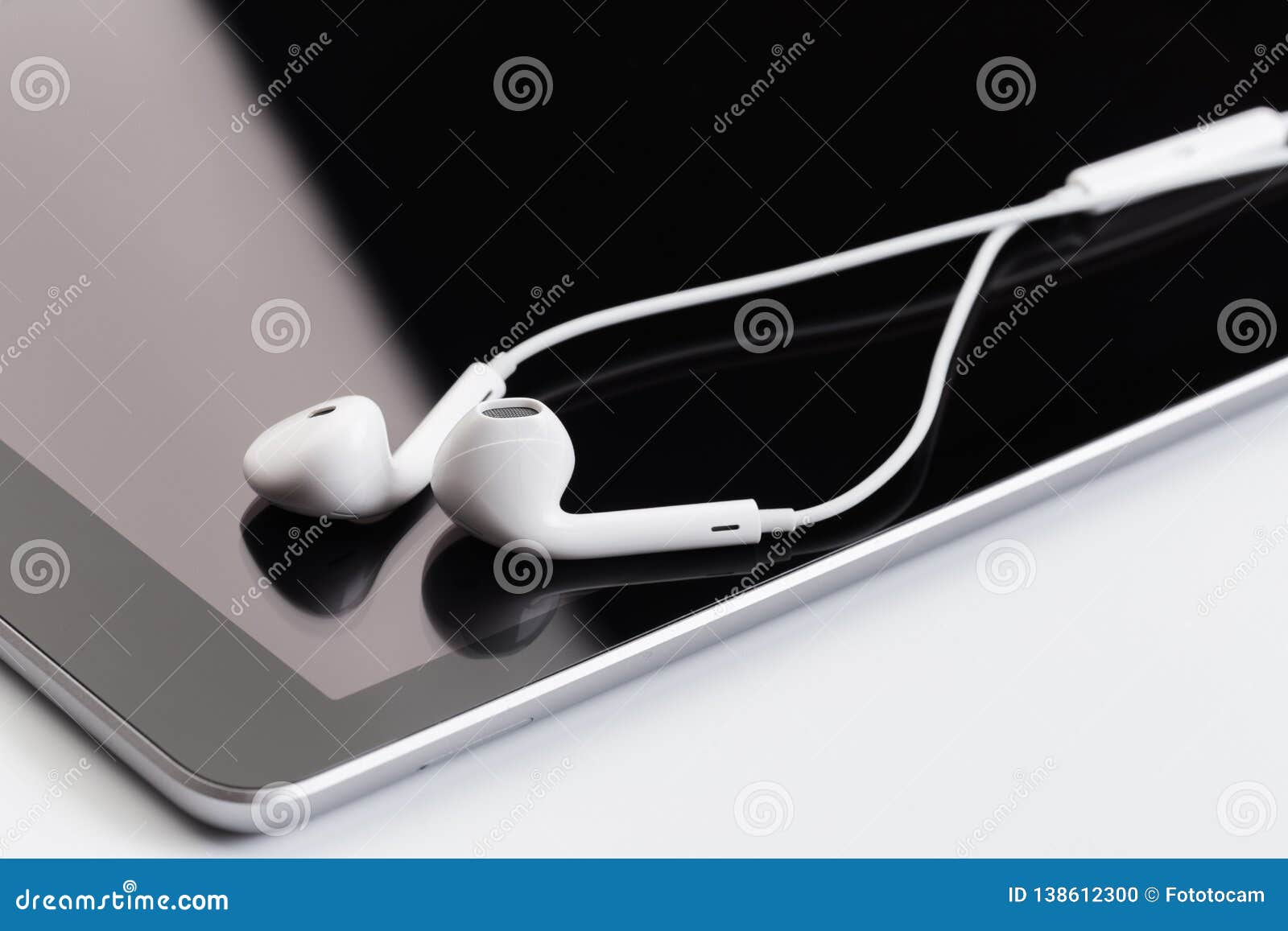 White earphones on tablet stock photo. Image of device - 138612300