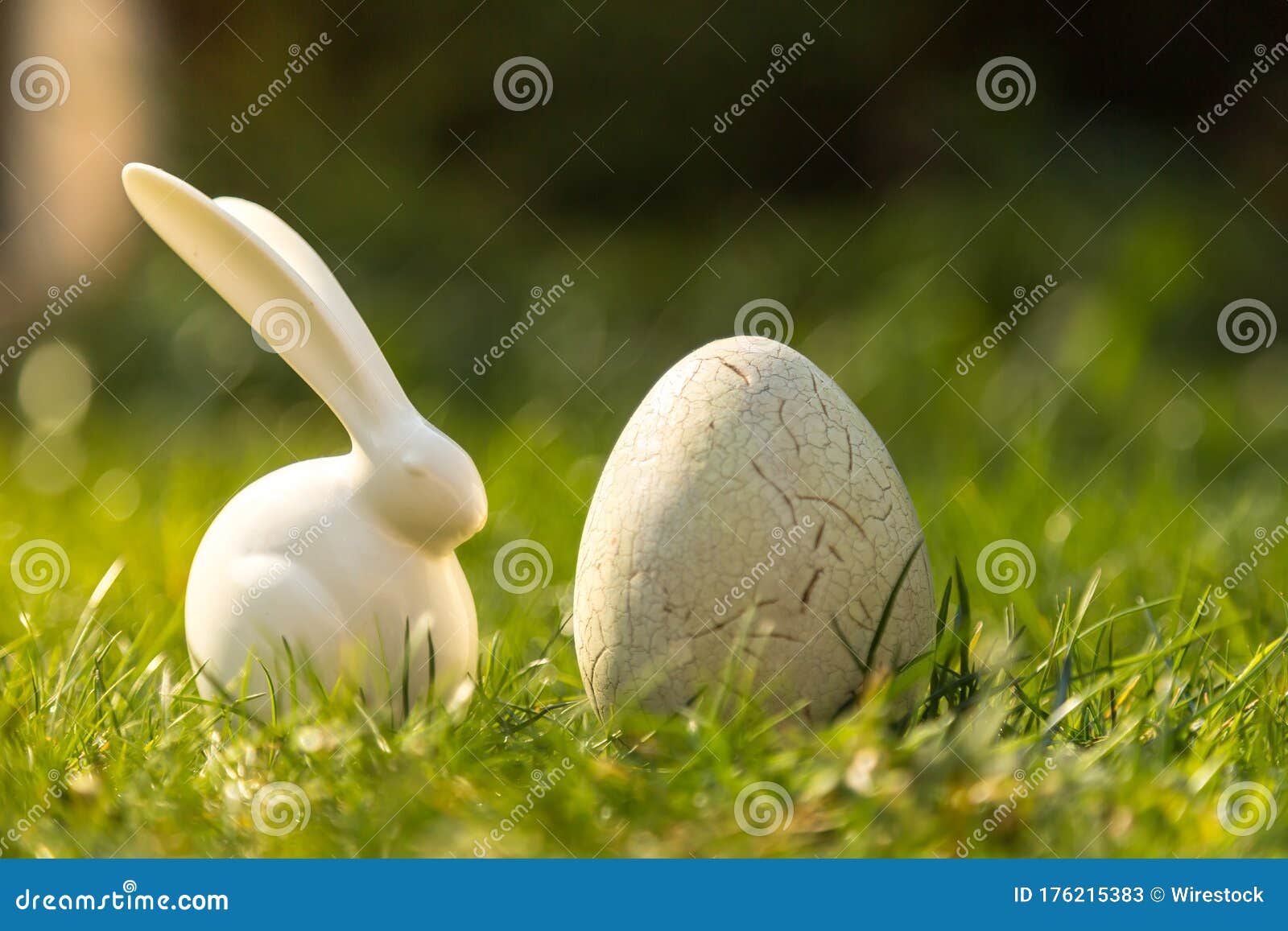 White Easter Bunny Figures and Dyed Eggs on the Green Grass in the ...