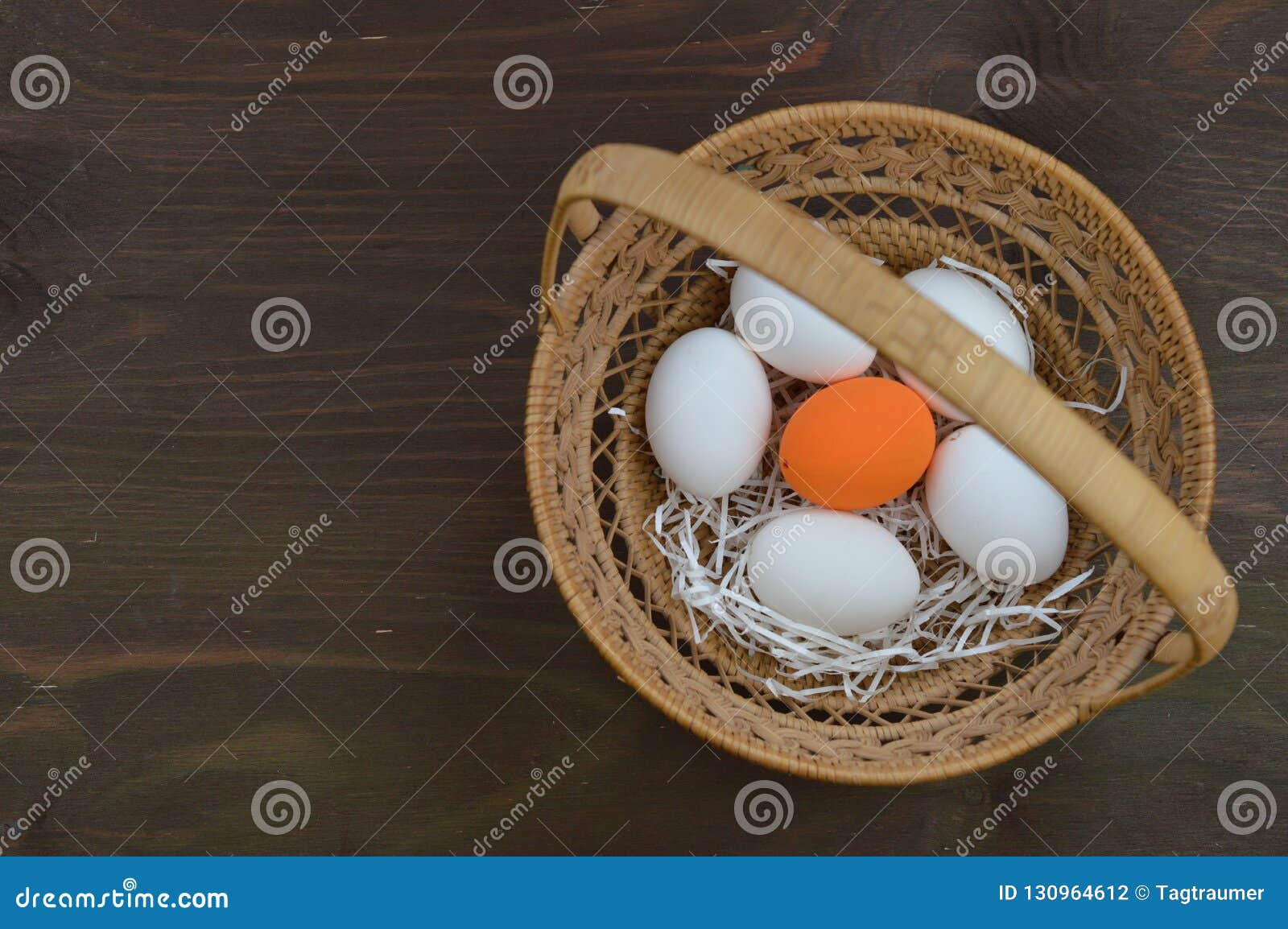White Eggs and One Orange Colored Egg in a Basket Stock Photo - Image ...