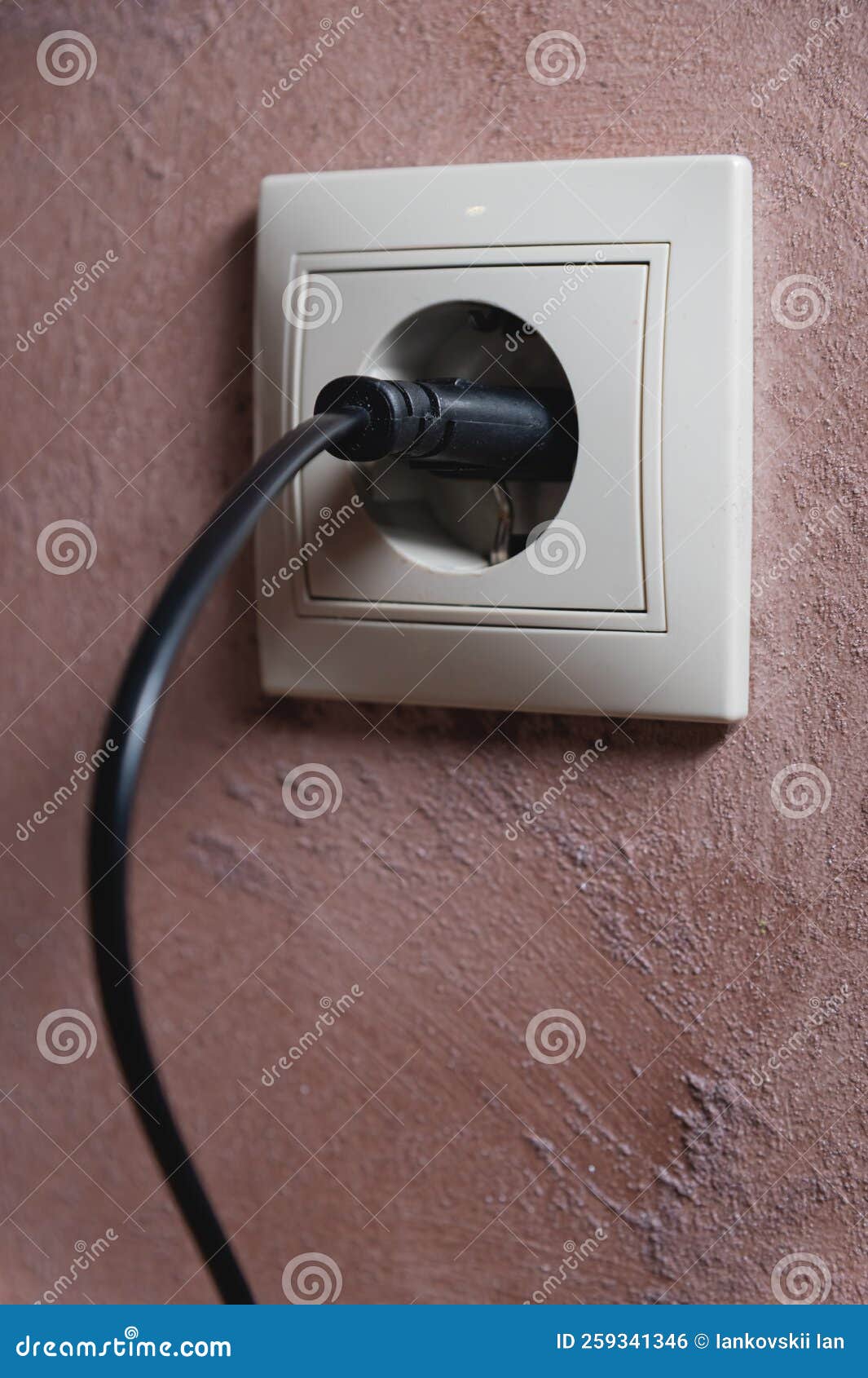 White Electrical Outlet on the Wall with a Black Wire Inserted. Close ...