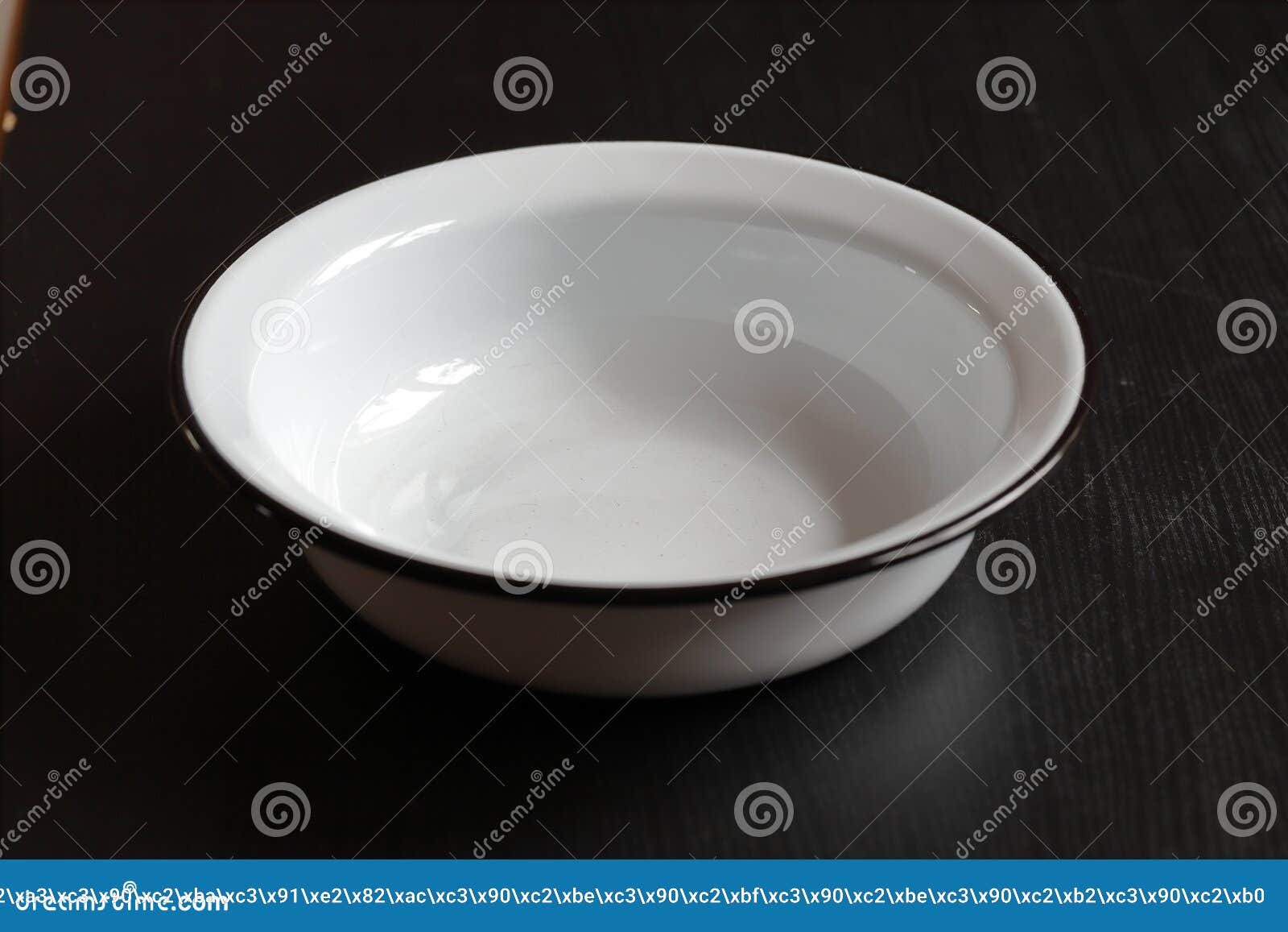 A White Enameled Empty Clean Bowl Stands on a Dark Table Against a ...
