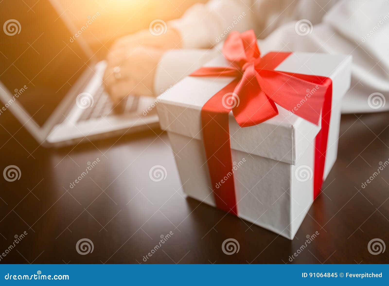 White Gift Box with Red Ribbon and Bow Near Man Typing on Laptop Stock ...