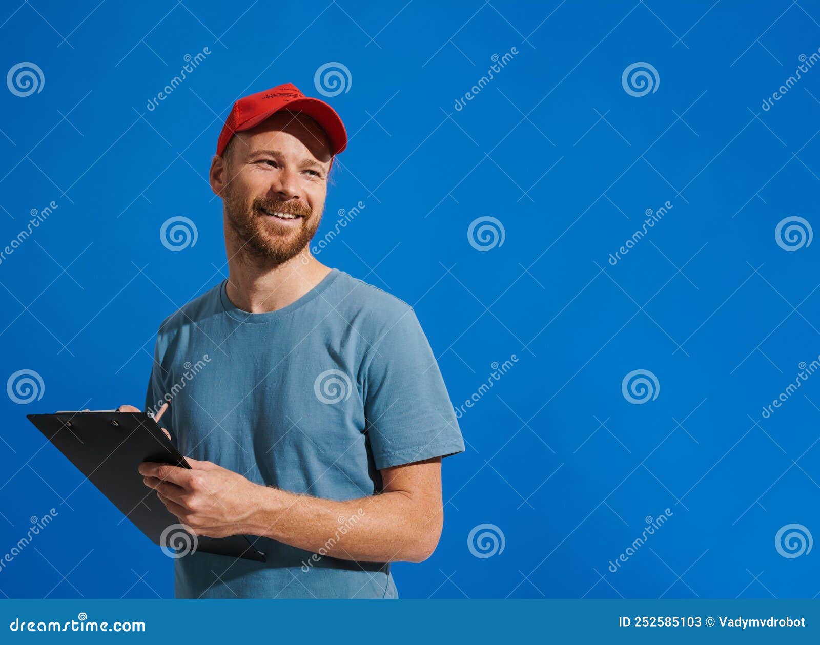 White Ginger Man Wearing Cap Smiling and Writing on Clipboard Stock ...