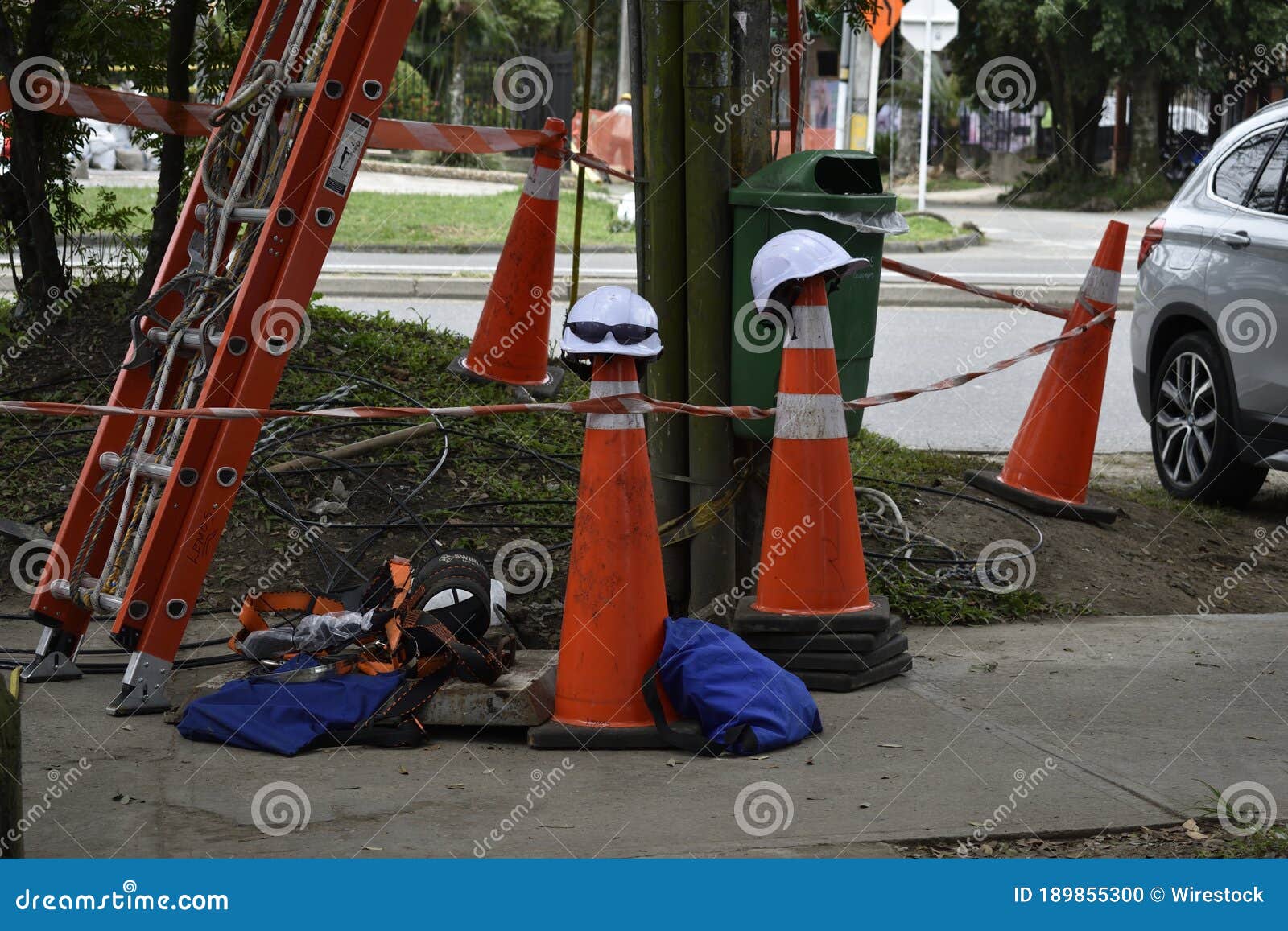 White Hard Hat on Top of a Safety Cone with Extension Ladder on a ...
