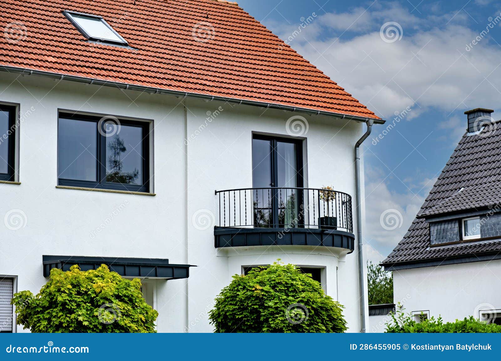 White House with Red Roof and Decorative Balcony on the Second Floor in ...
