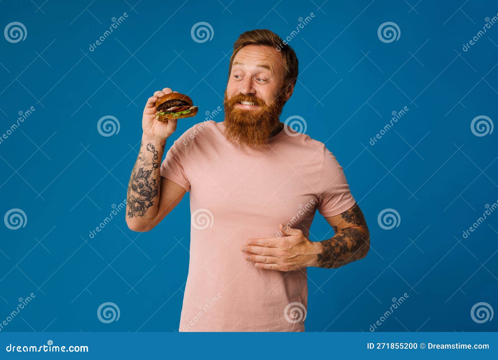 Happy Hungry Bearded Man Eating Burger Isolated on Blue Background ...