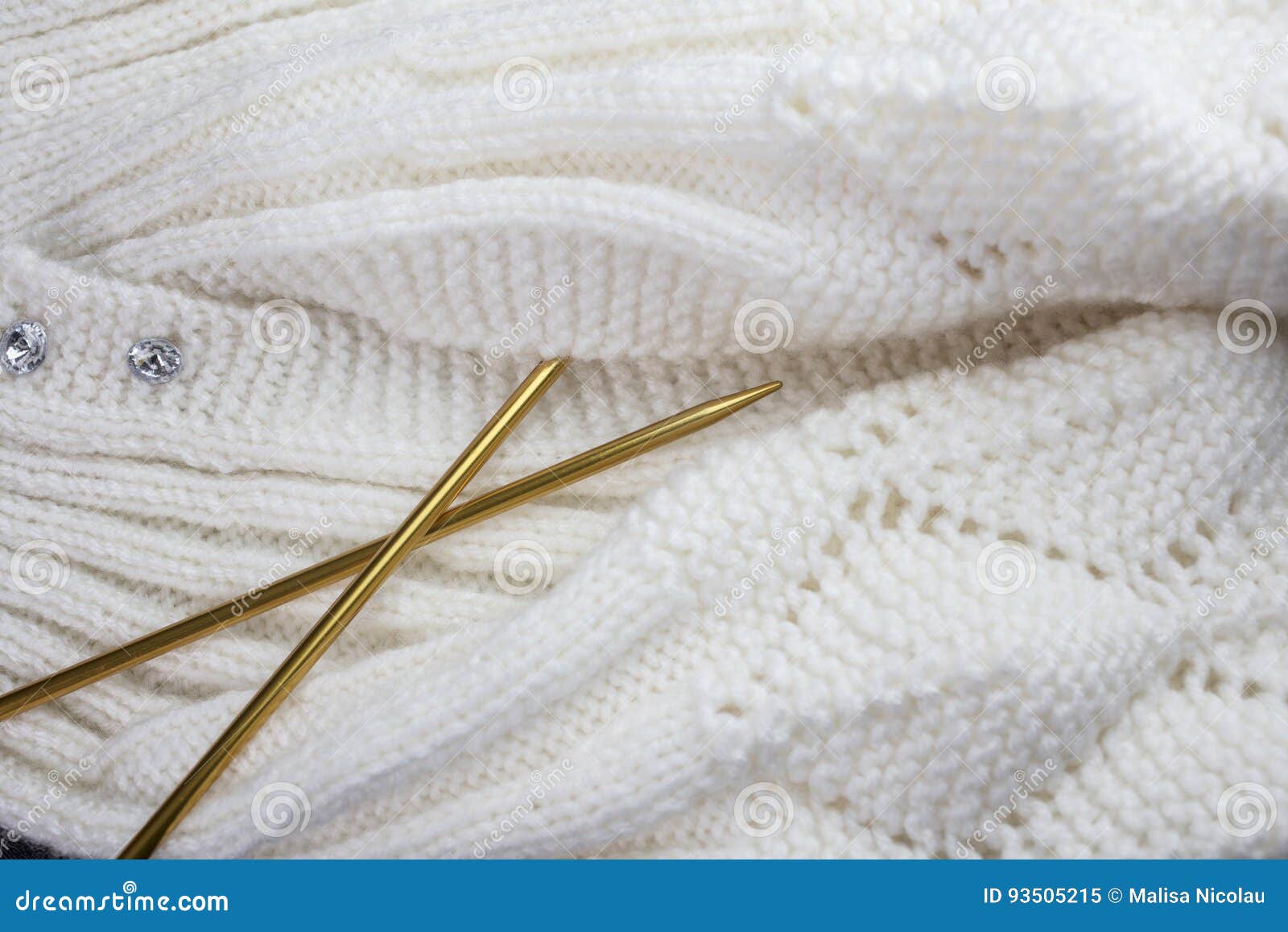 White Knitted Garment with Gold Colored Knitting Needles Stock Image ...