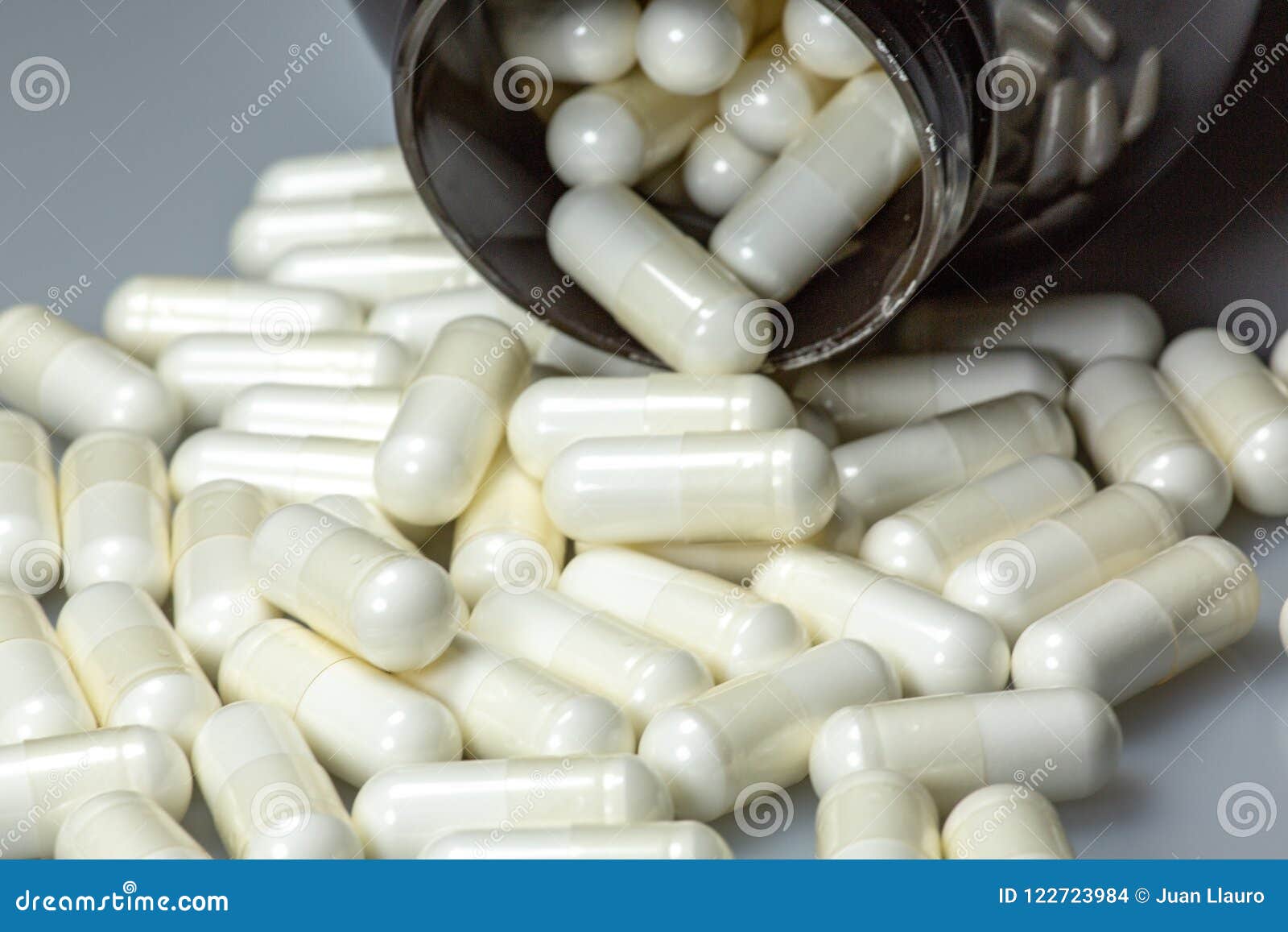 White Large Pills Falling Out of a Large Pill Bottle Stock Photo ...