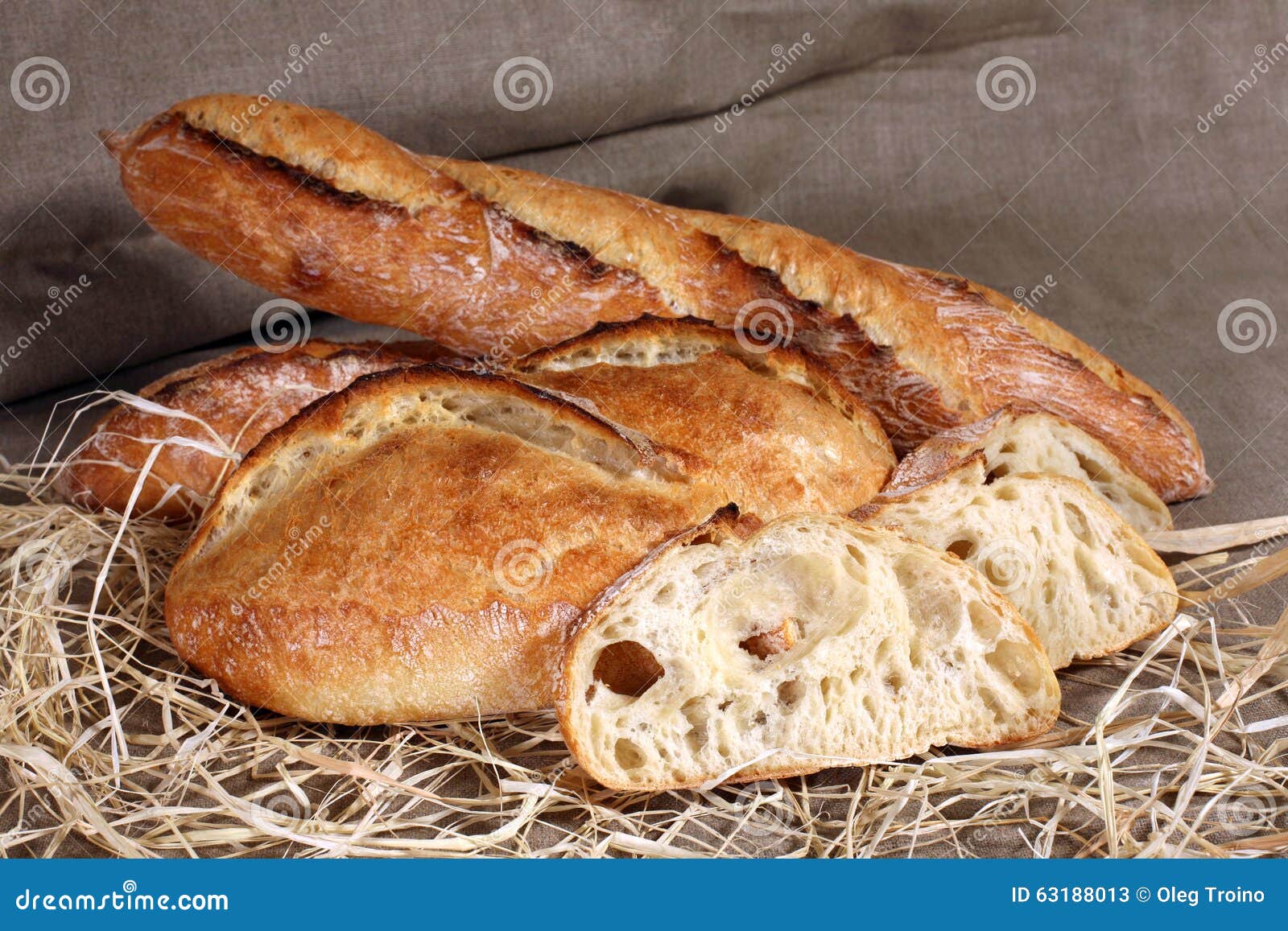 White Loaves of Different Shapes Lying in Straw on Grey Linen Ta Stock ...