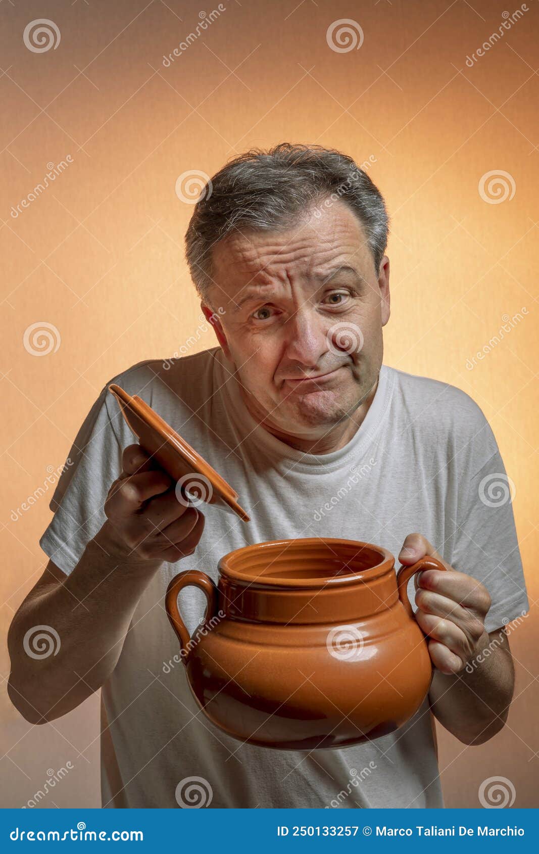 A Man Holds a Clay Pot in His Hands with an Expression of ...