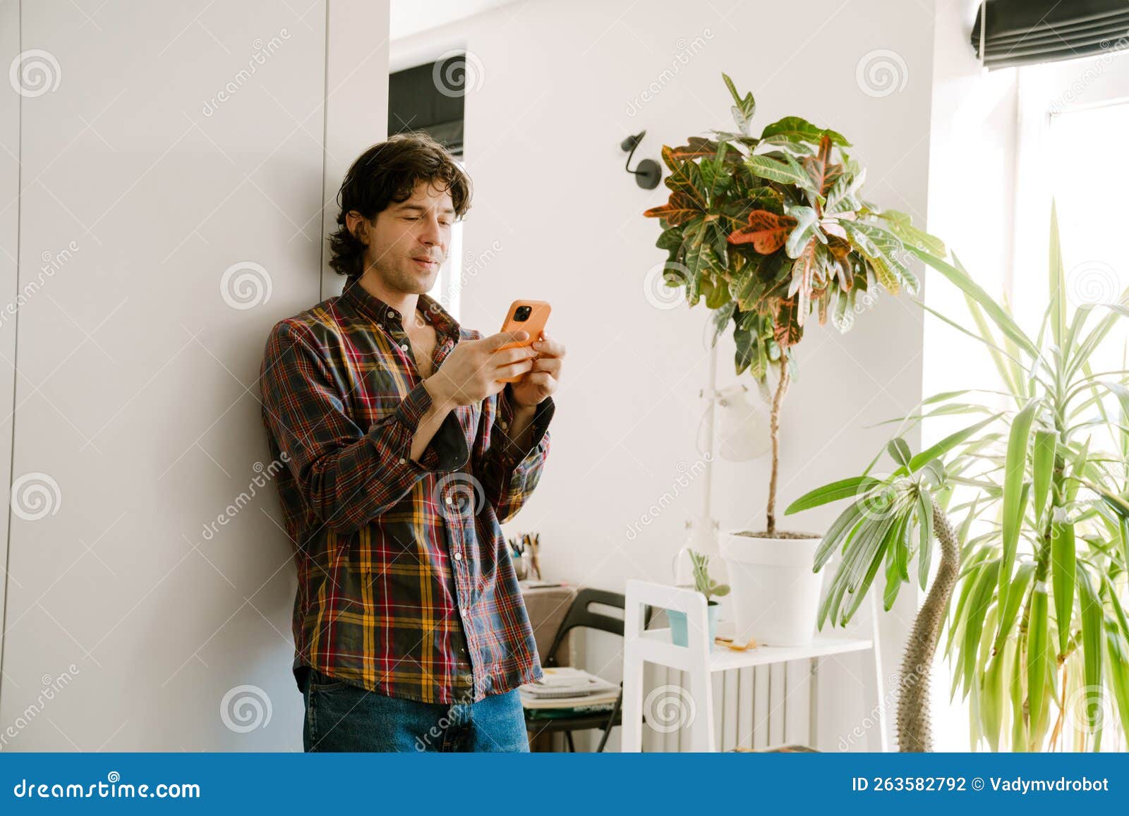 White Man Smiling and Using Mobile Phone at Home Stock Photo - Image of ...