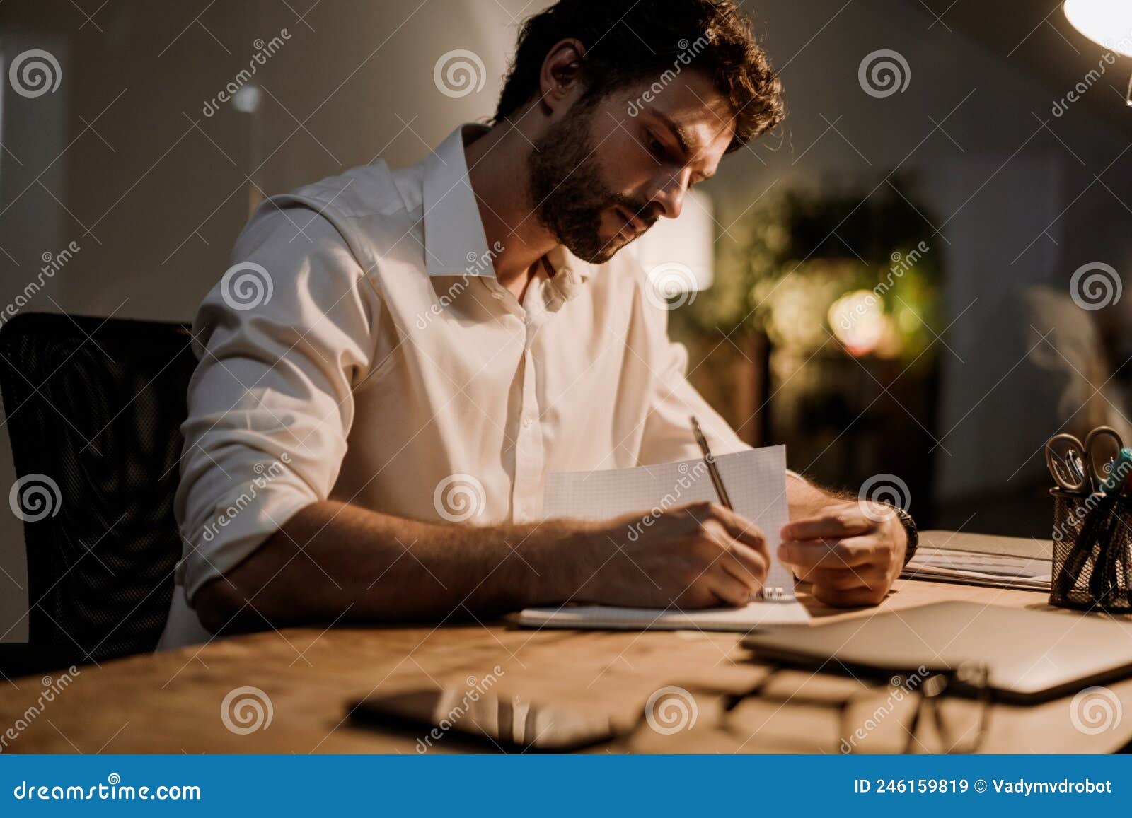 White Man Writing Down Notes in Planner while Working at Office Stock ...