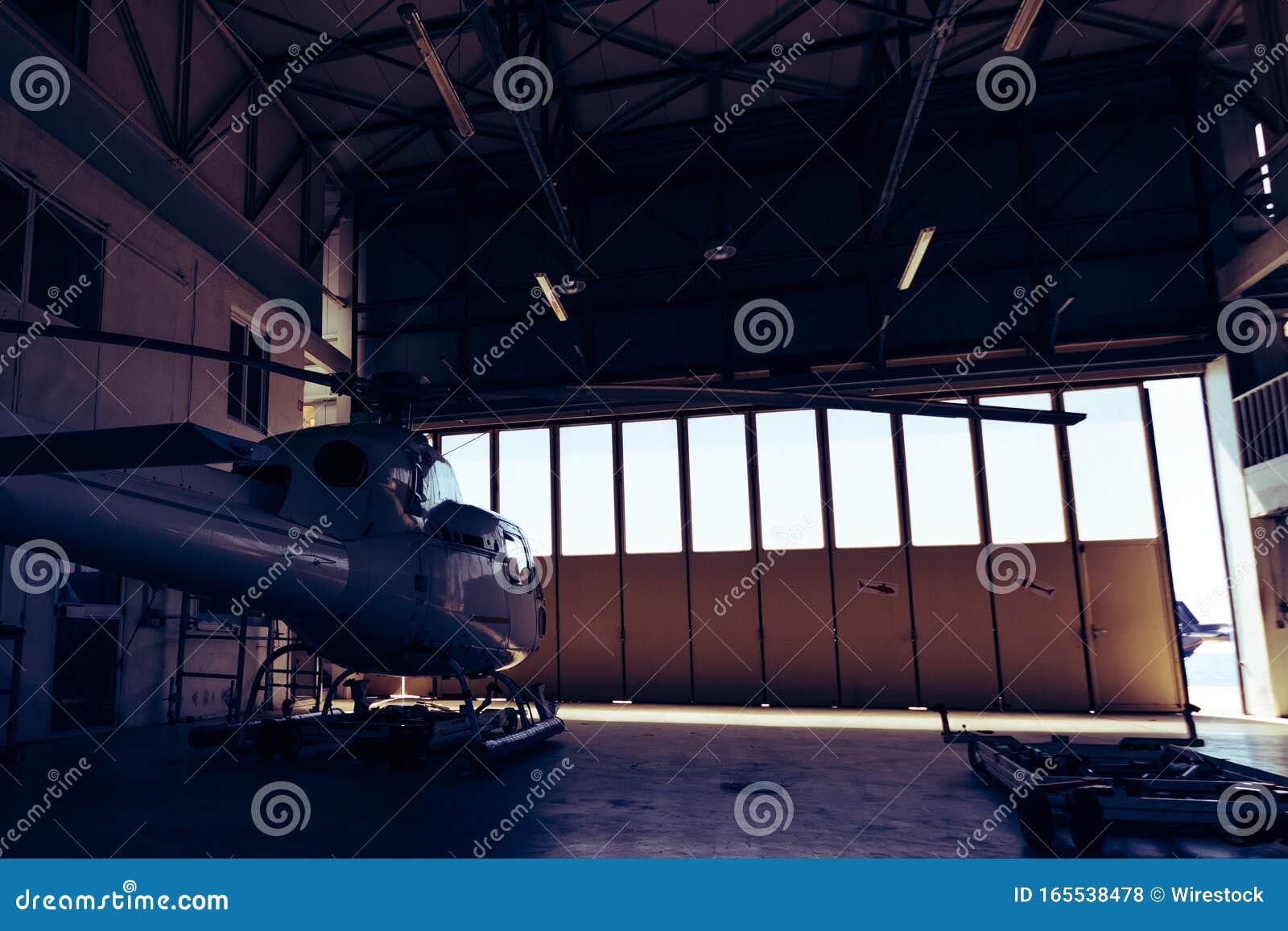 White Military Helicopter Parked Inside a Garage with a Closed Gate ...