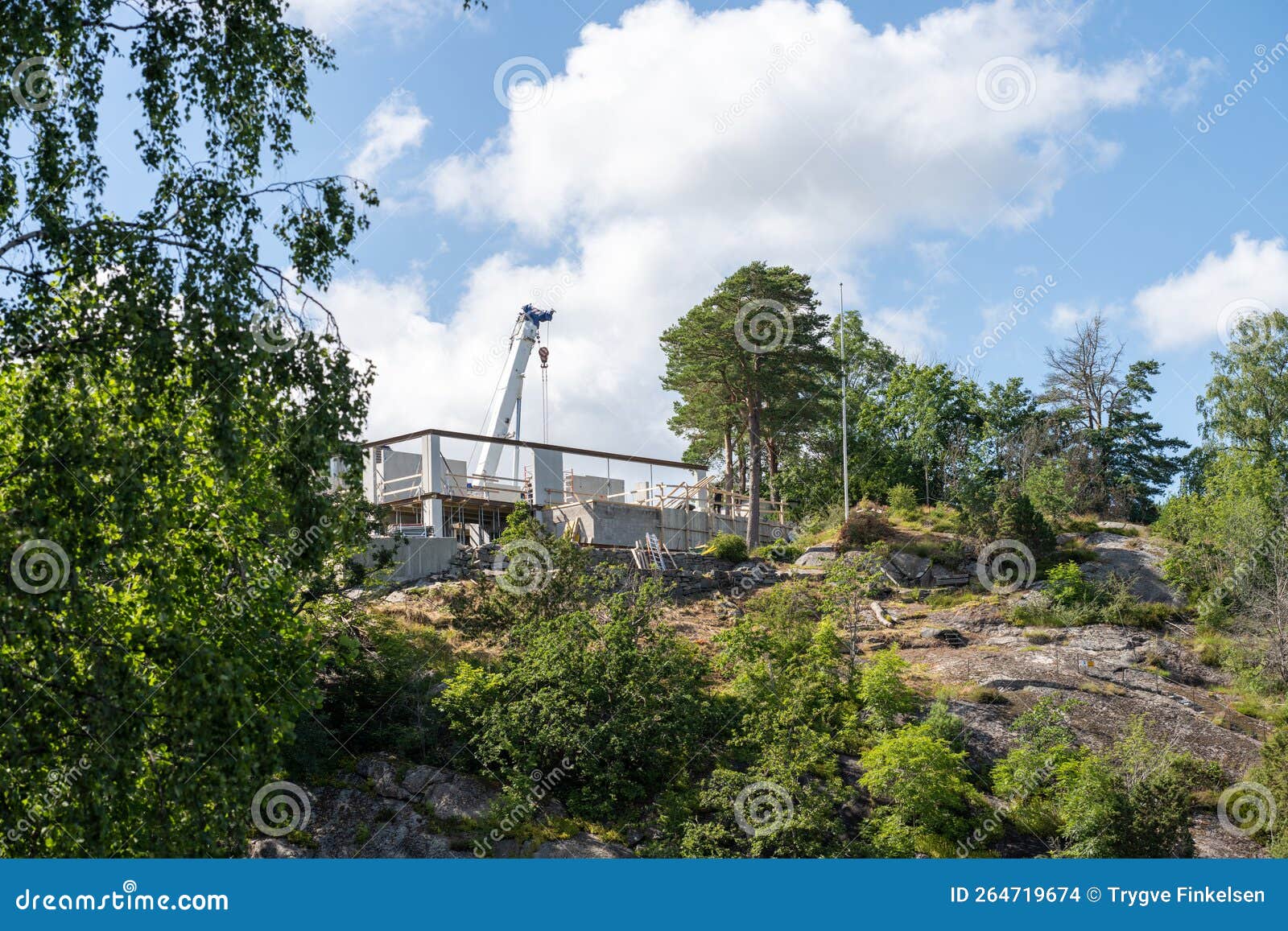 White Mobile Crane Towering Over a House on a Hill Under Construction ...