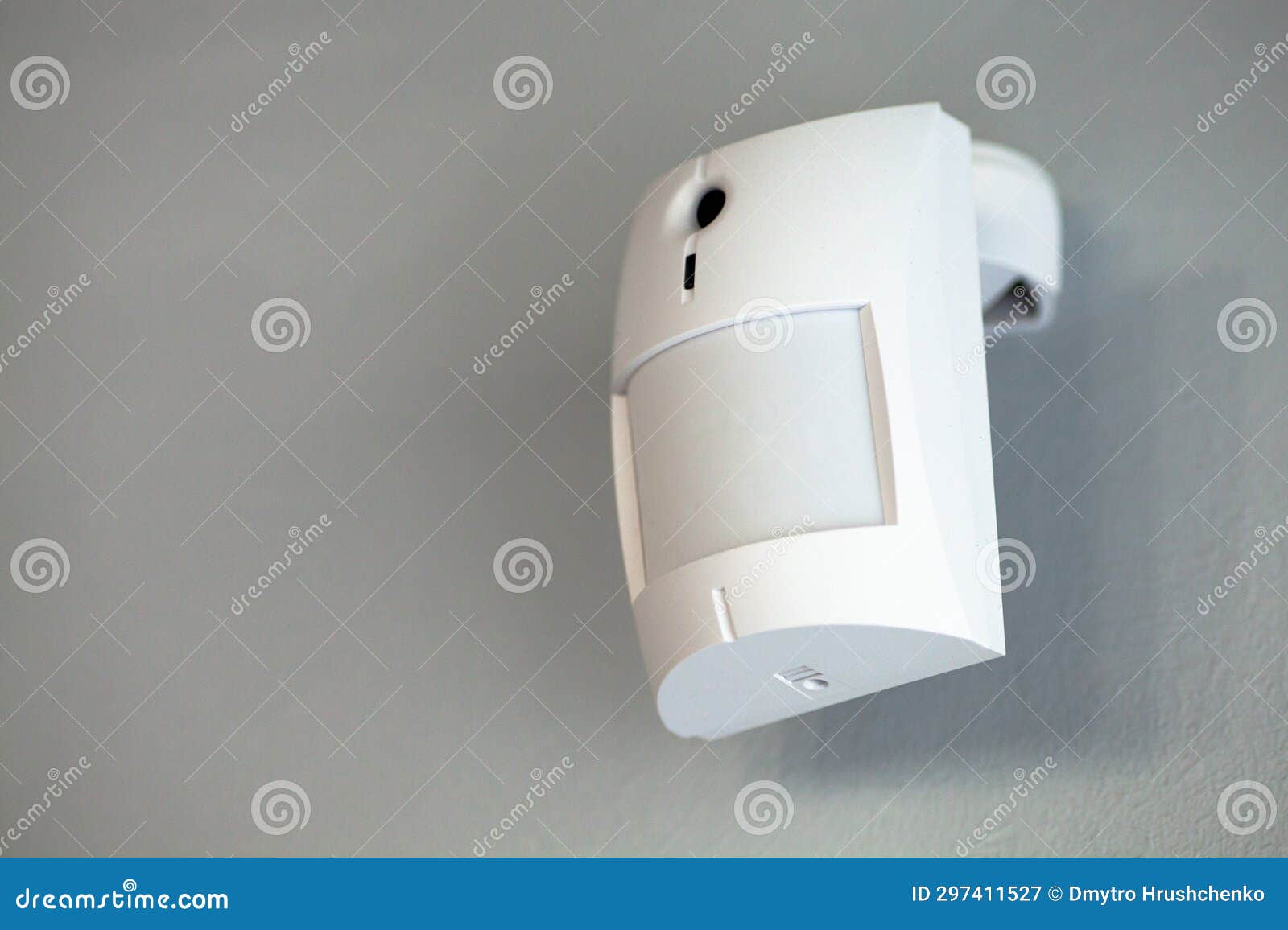 A White Motion Sensor Camera on a Gray Wall, Providing Security and ...
