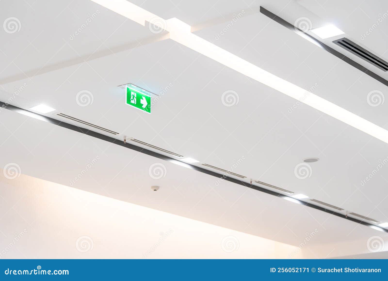 White Neon Sign Depicting a Fire Exit with Green Background Hangs from ...