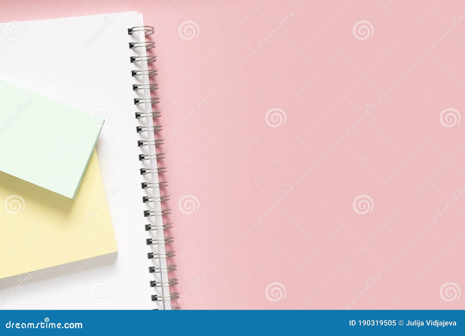 A White Notebook with a Spiral and Two Multi-colored Stickers on Top ...