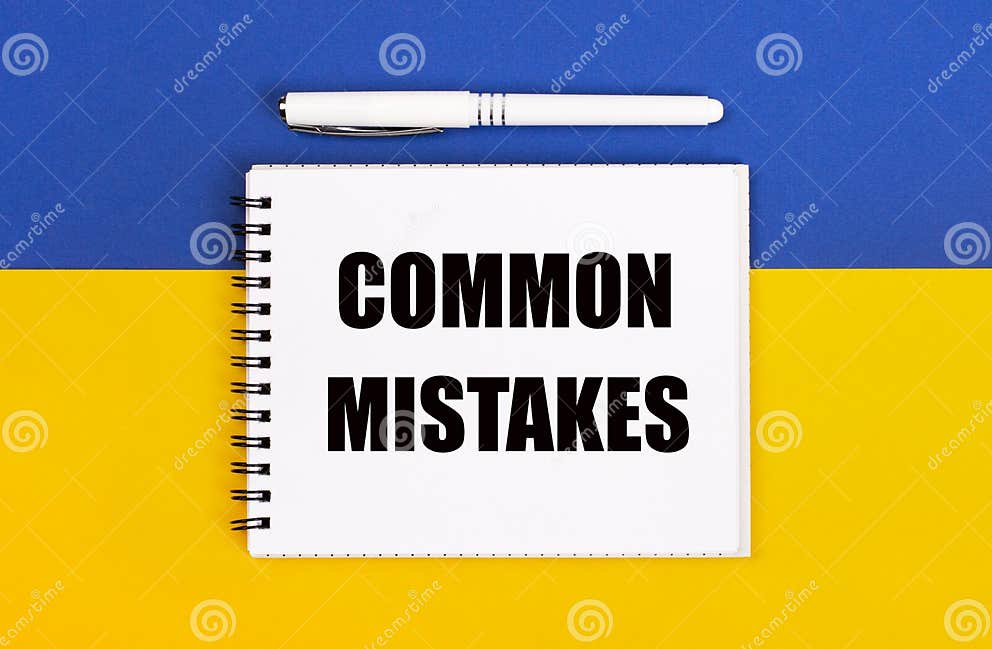 A White Notebook with the Text COMMON MISTAKES and a White Pen on a ...