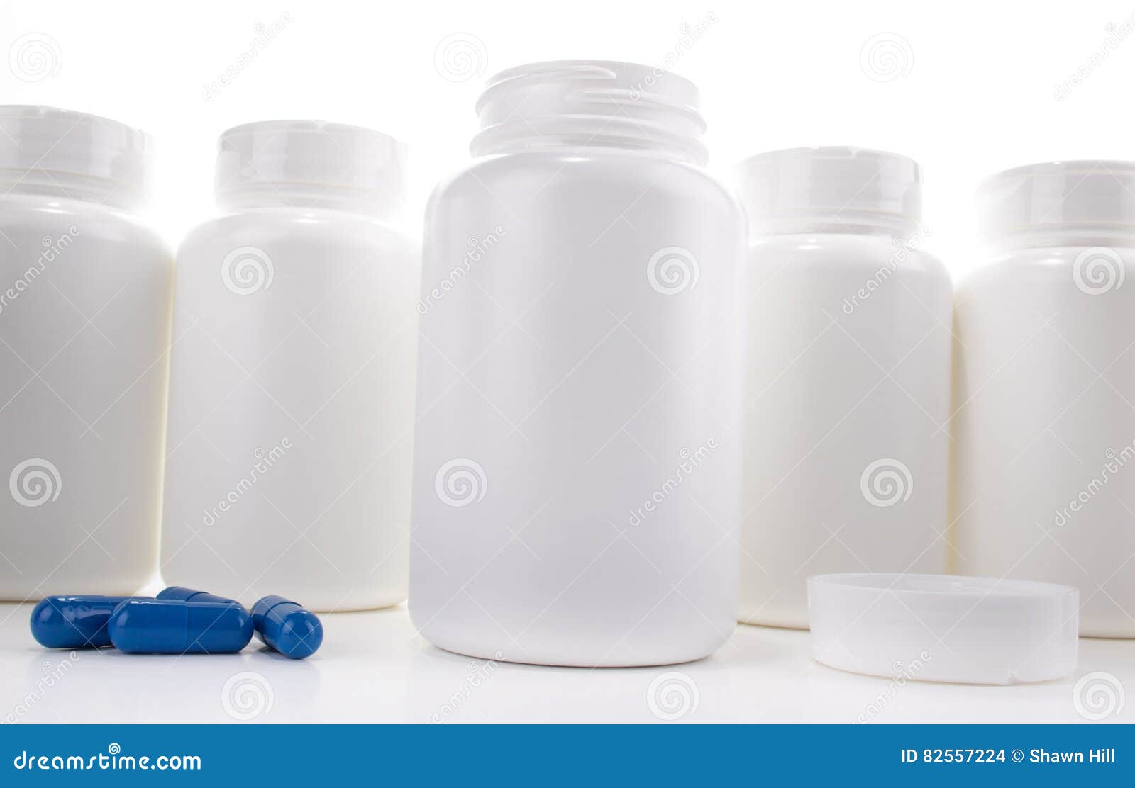 White Pill Bottle Open on Counter between Cap and Blue Pills Stock ...