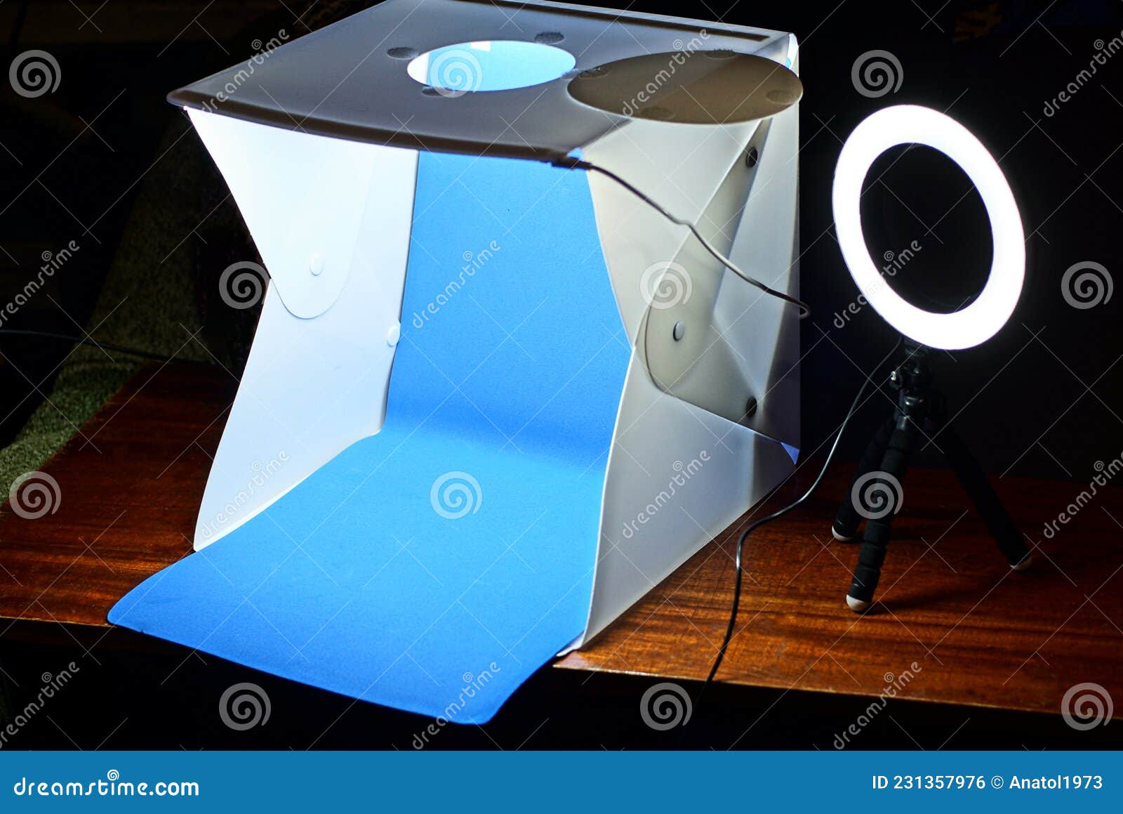 A White Plastic Lightbox with a Blue Background and a Selfie Ring Lamp ...