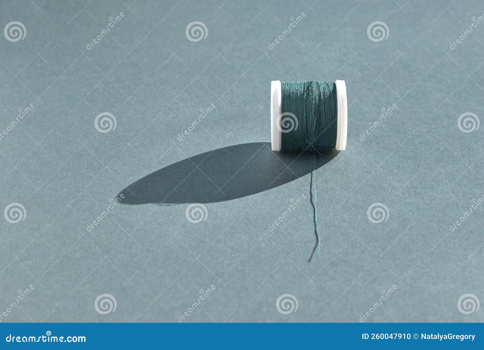 A White Plastic Spool of Sewing Thread in a Beautiful Emerald Color ...