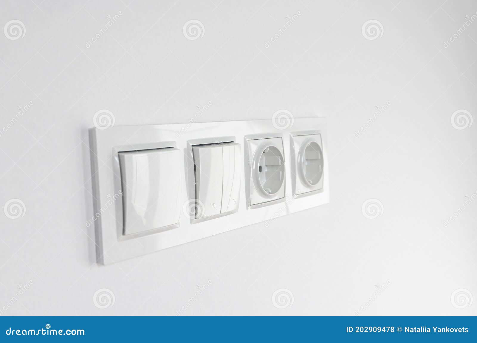 White Plastic Walk-through Switches and Sockets on a White Wall Stock ...