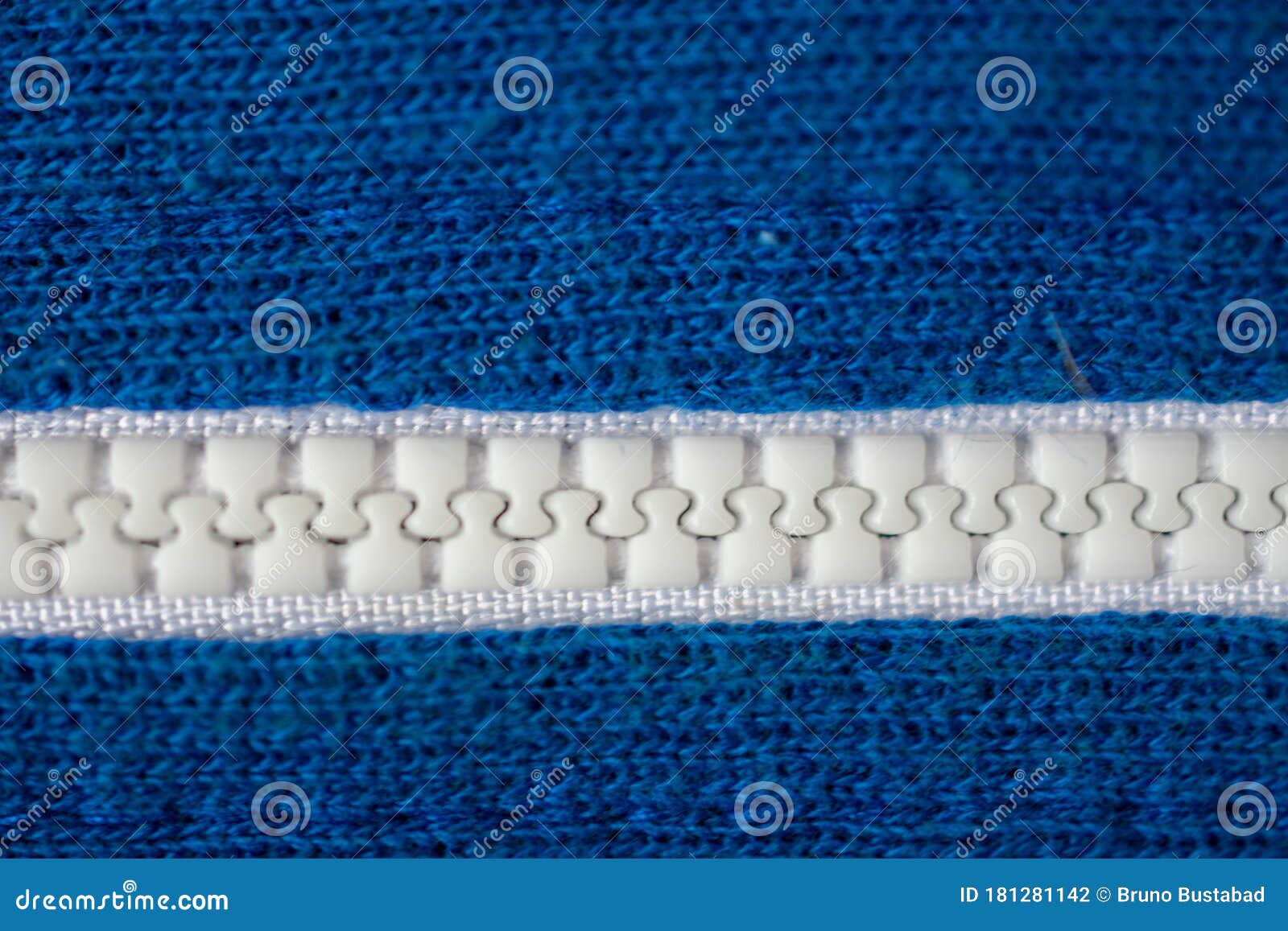 White Plastic Zipper Closed in the Middle of a Blue Fabric Texture ...