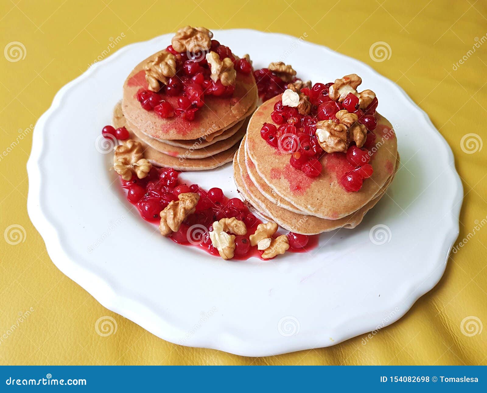 A White Plate with Stacks of Pancakes with Red Currant and Walnuts ...