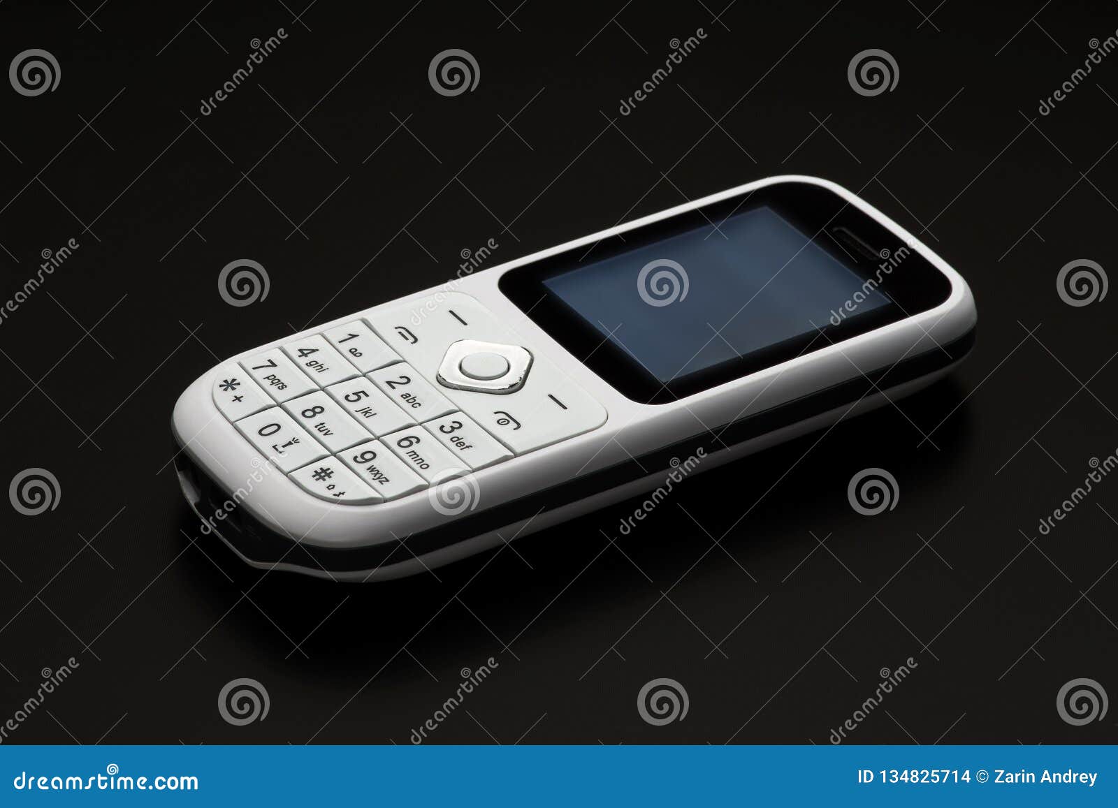 White Push-button Mobile Phone of the Old Model on a Black Background ...