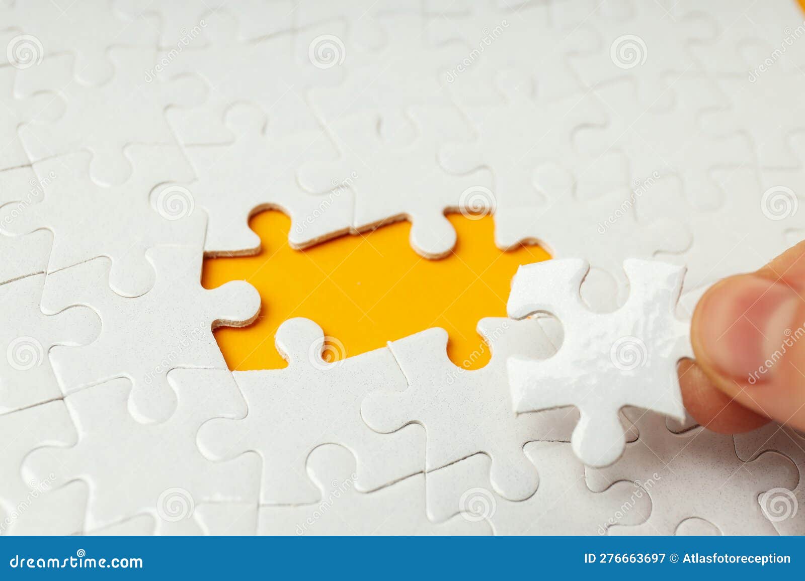 White Puzzles without Two Puzzles on Orange Background and Fingers Hold ...