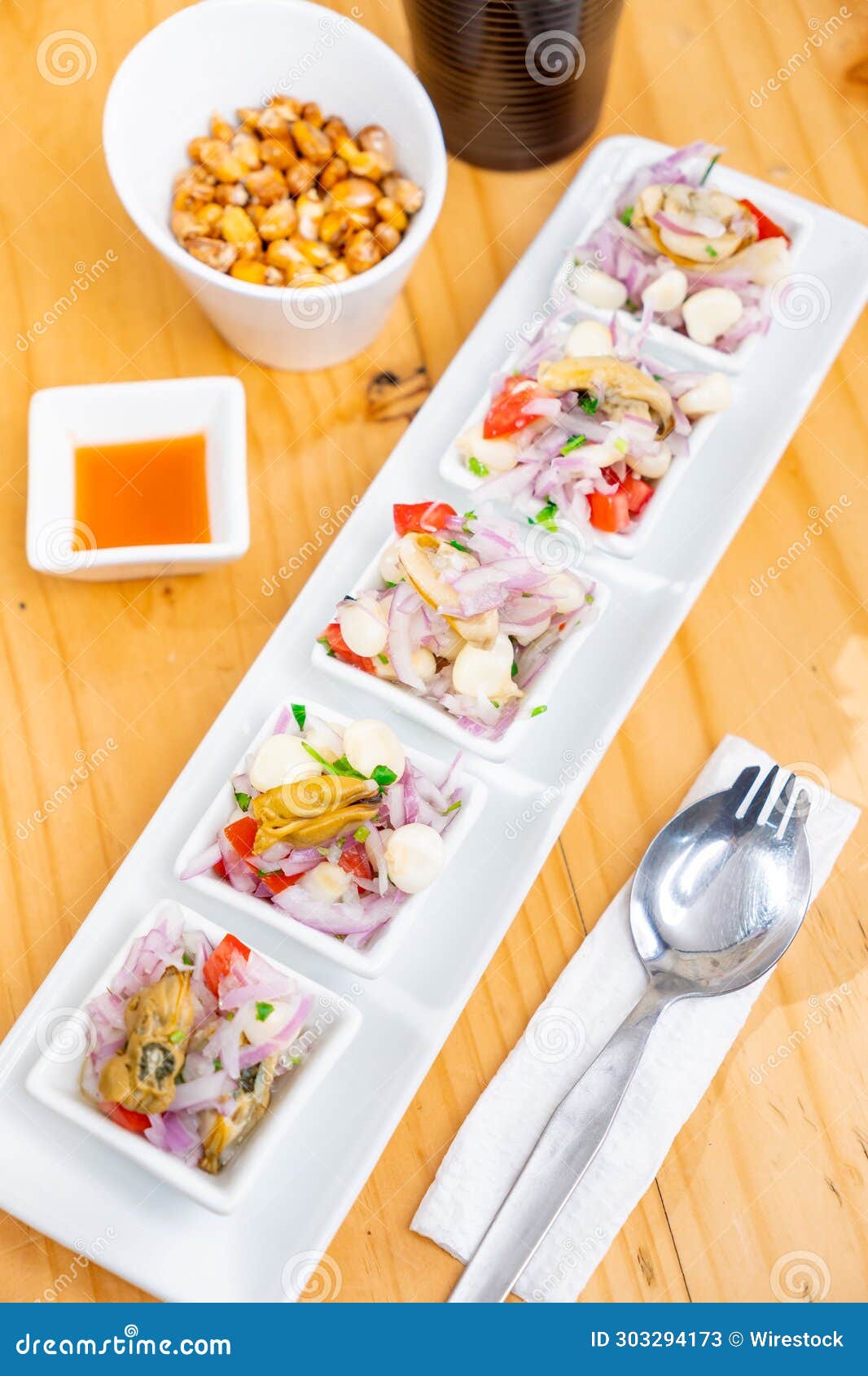 Several Dishes Sit on a White Rectangular Plate with Two Spoons Stock ...