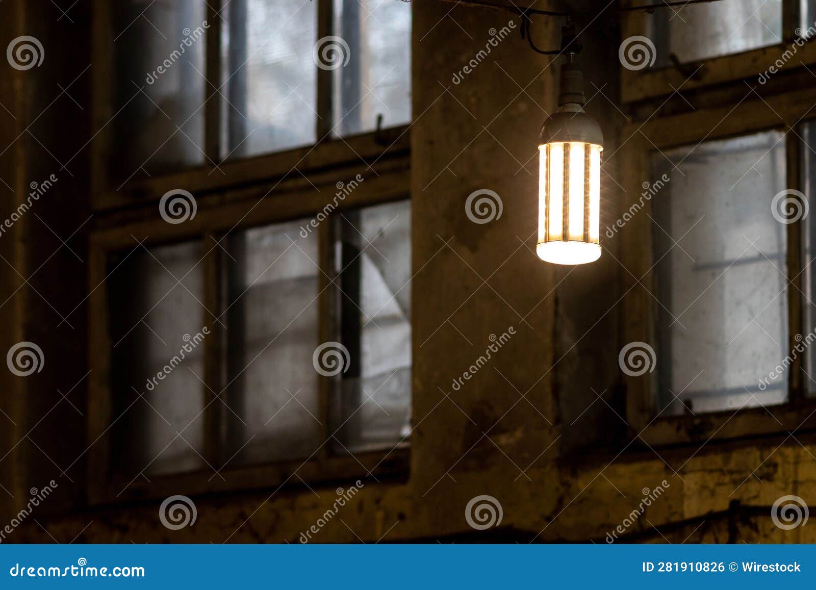 A Light Hanging from the Side of a Building Next To Windows Stock Photo ...