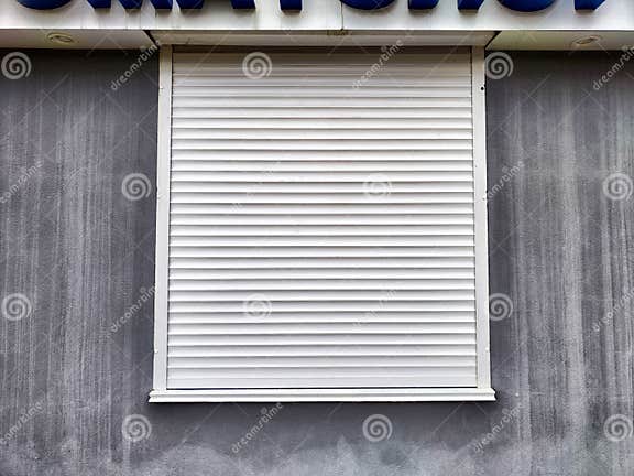 A White Rolling Shutter is Closed, Obstructing the Window of a Building ...