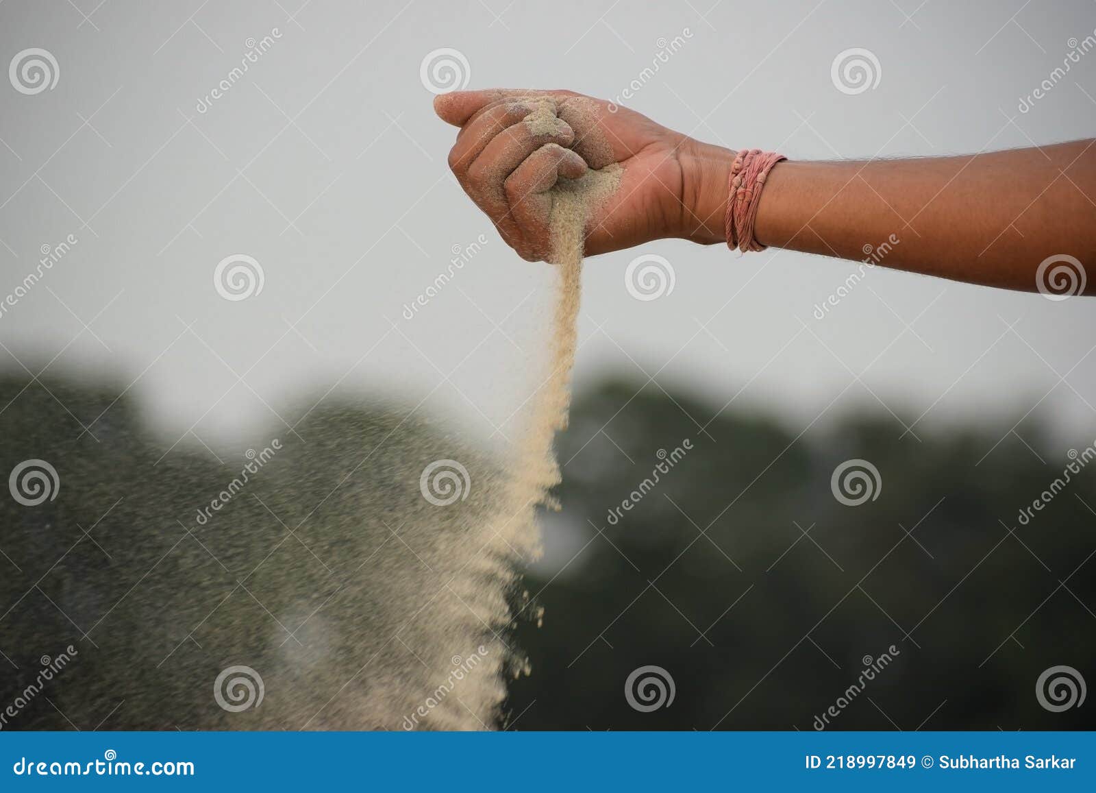 White Sand Falling from Hand in Outdoor and the Sand Particles are Floating in the Air Stock ...